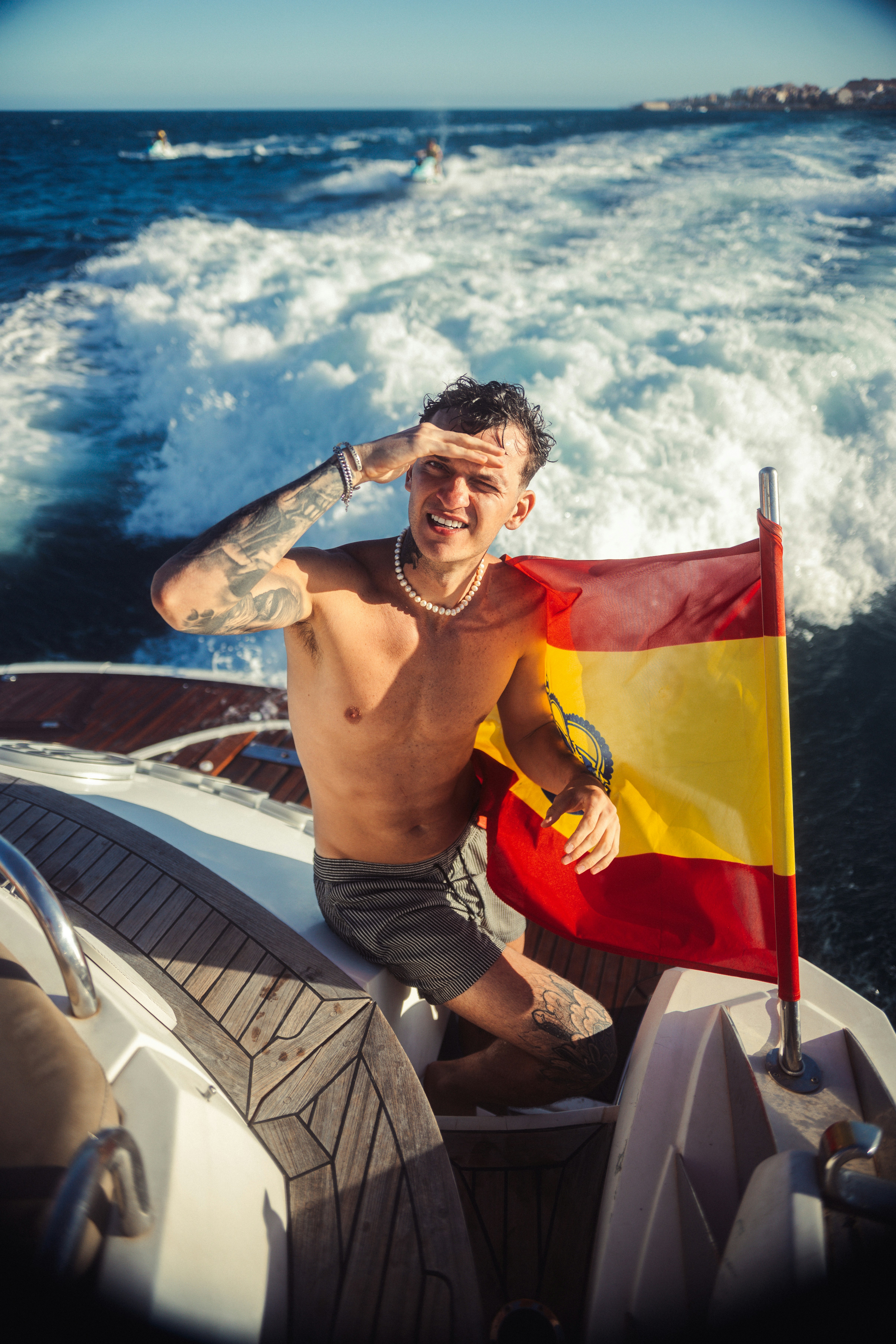 Man on a boat with spanish flag shields eyes