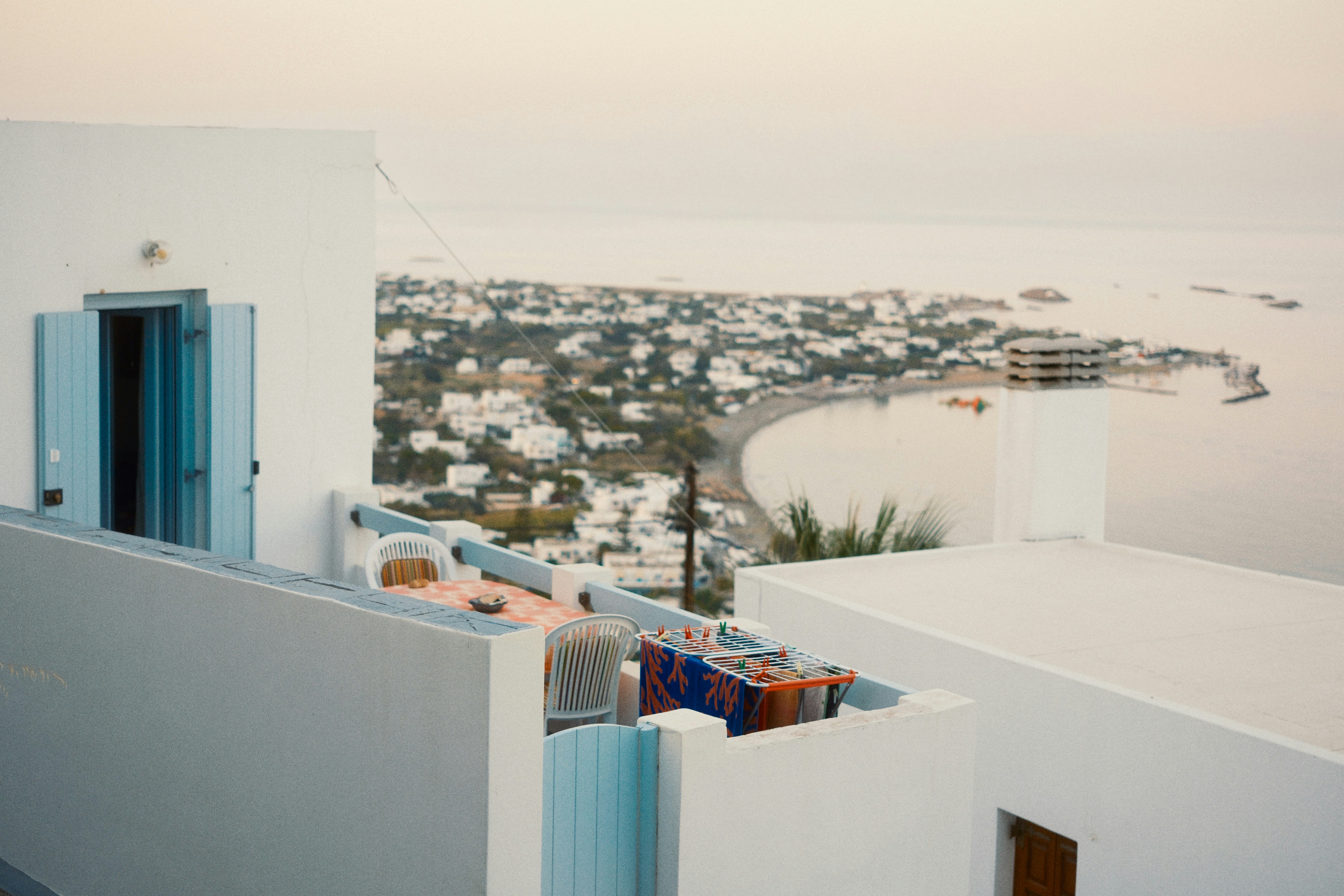 White buildings overlook a coastal town and calm sea.