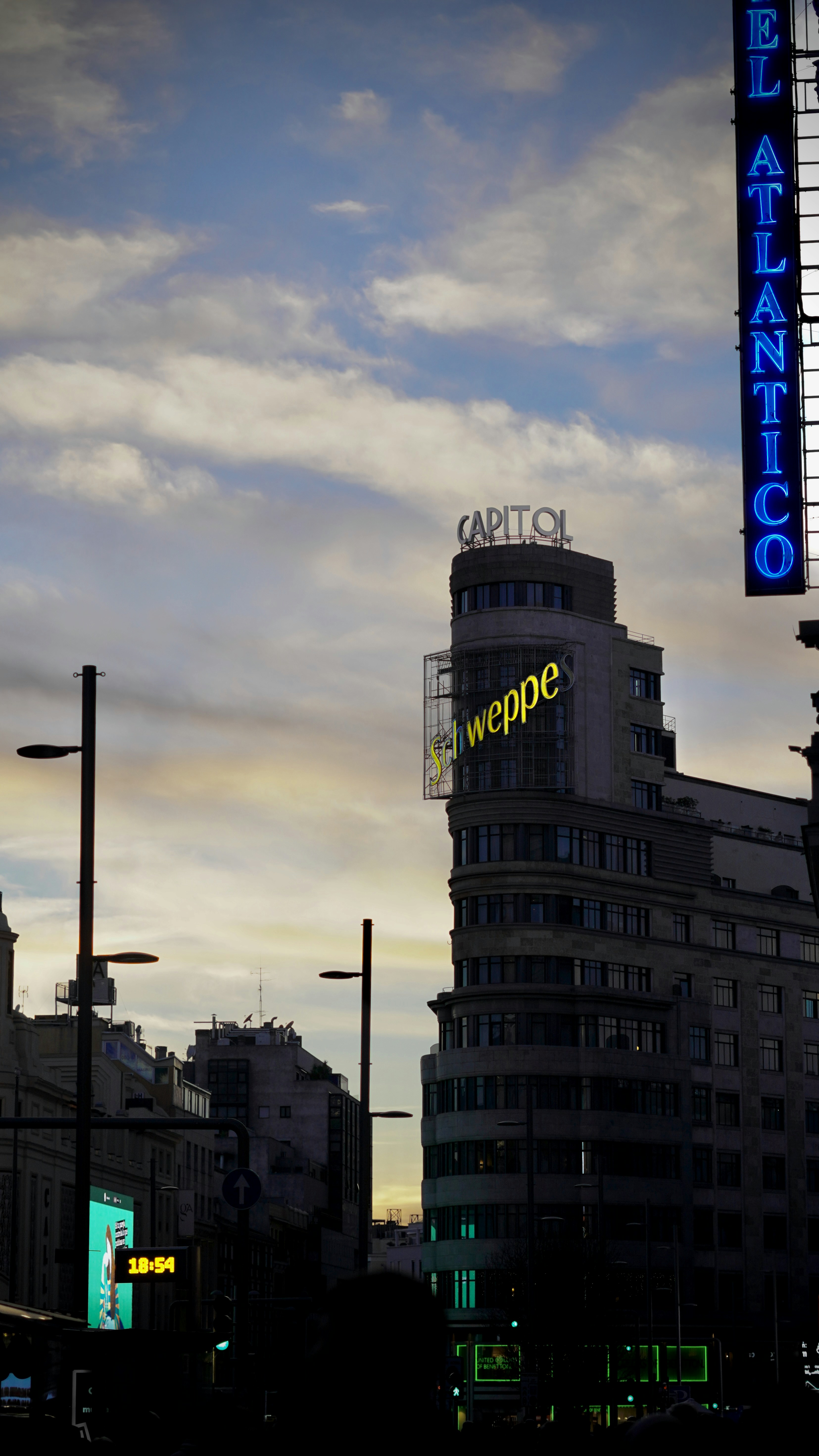 Capitol Cylinder at Neon Dusk: A Sign-Laced Street Embraced by Sunset Sky