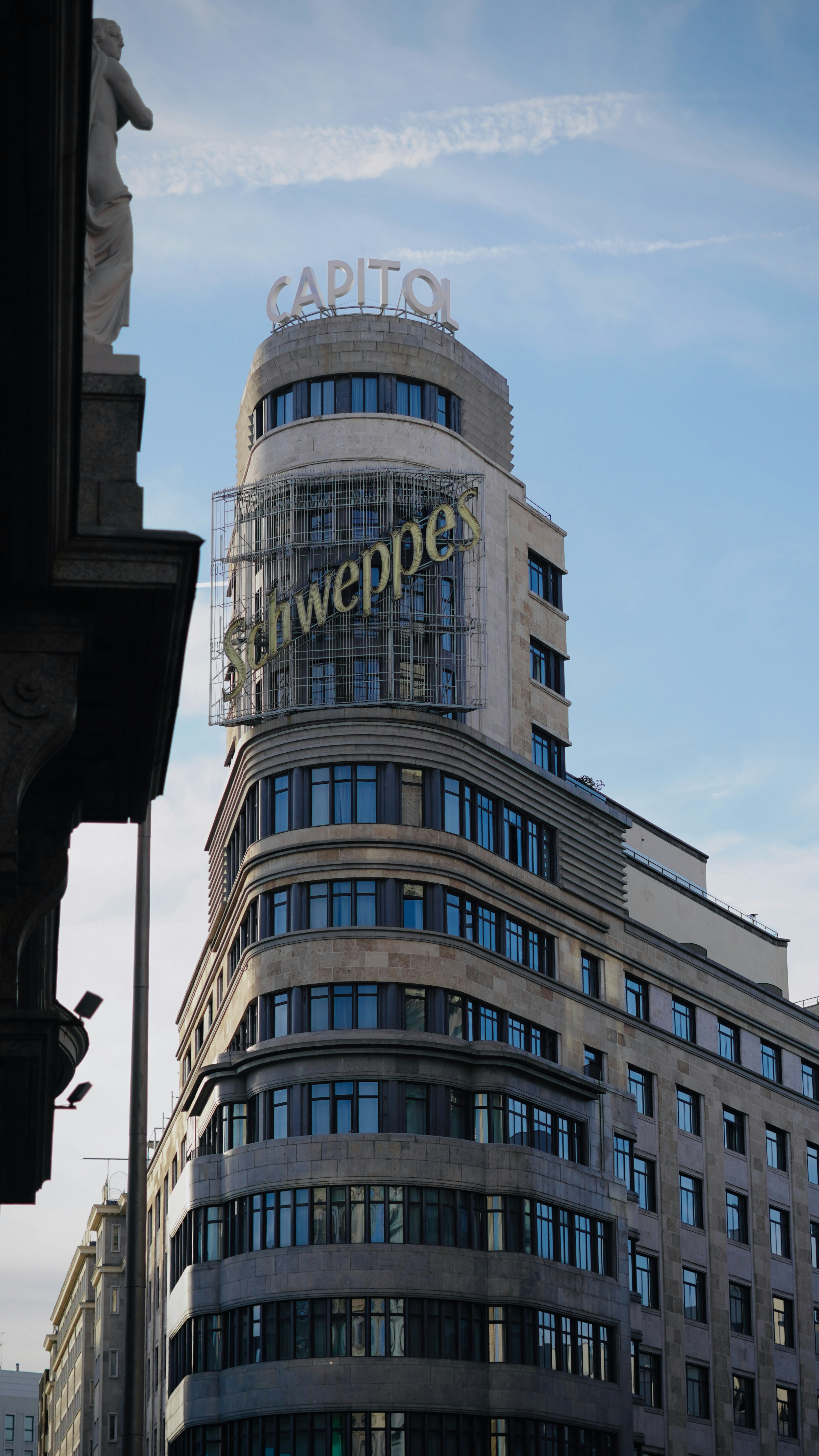 Capitol's Cylindrical Crest: Schweppes Sign Against a Clear Sky