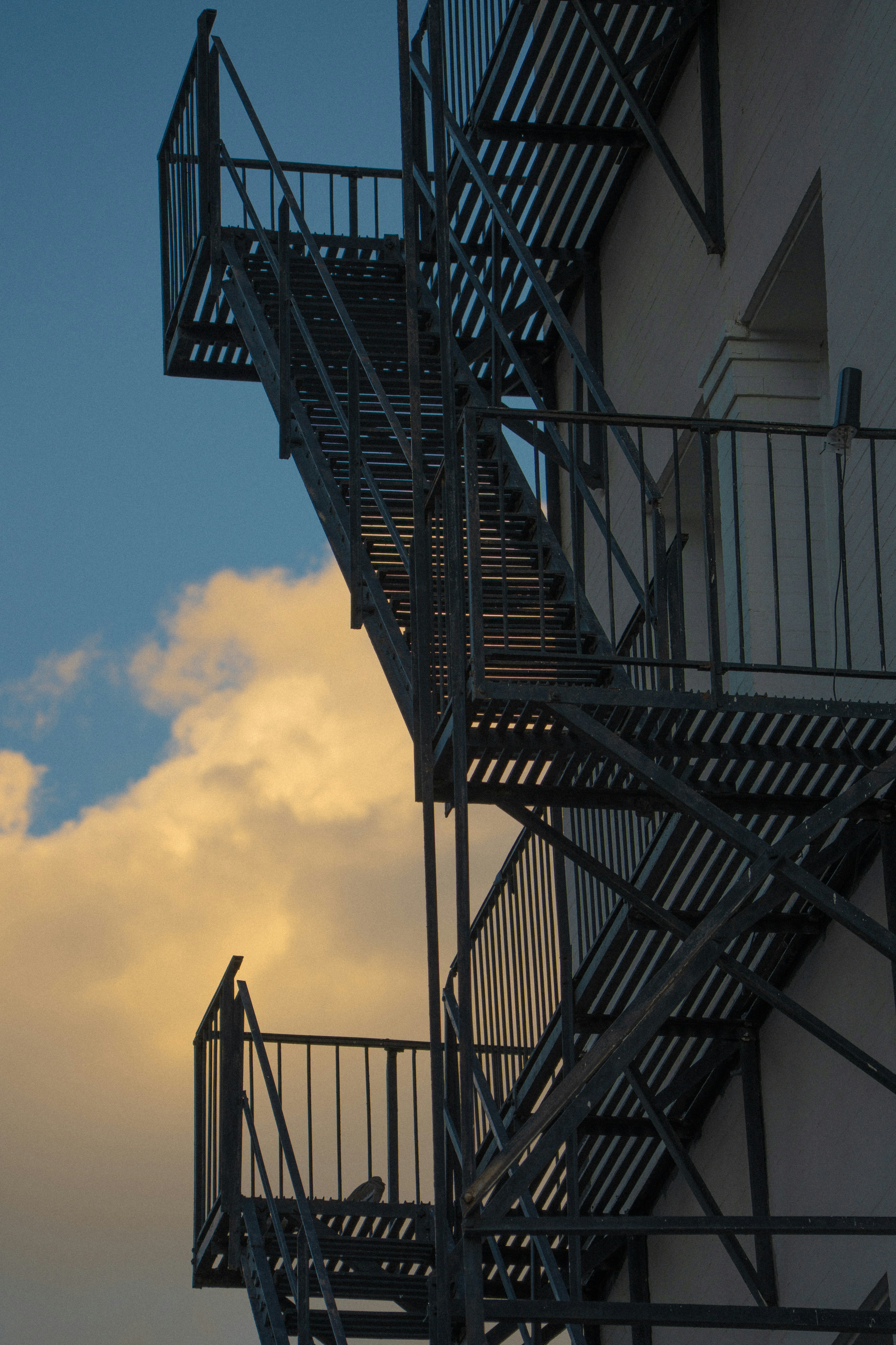 A metal fire escape against a cloudy sky