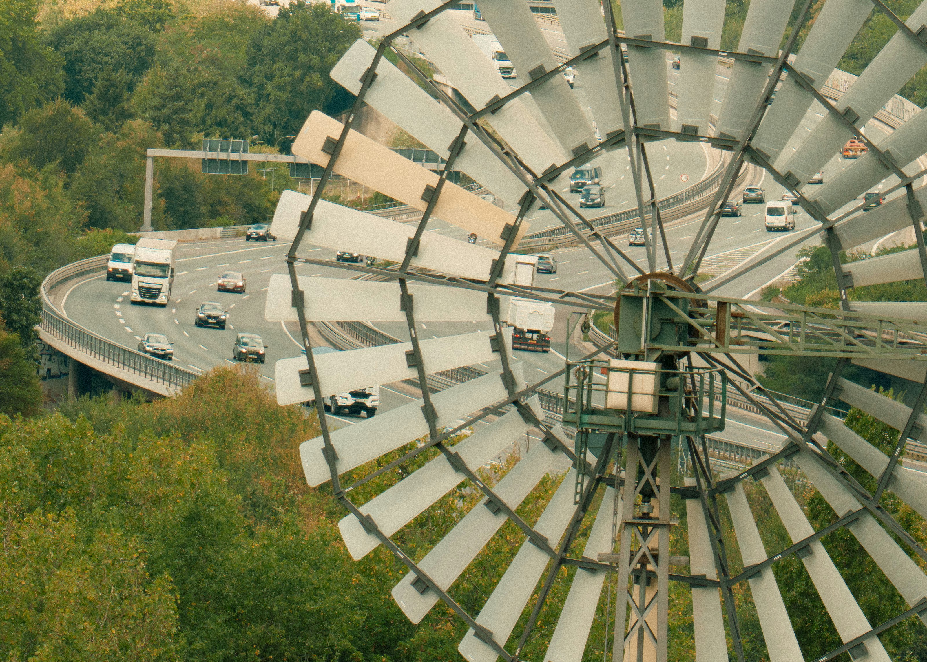 Giant windmill structure overlooks busy highway traffic photo – Free ...