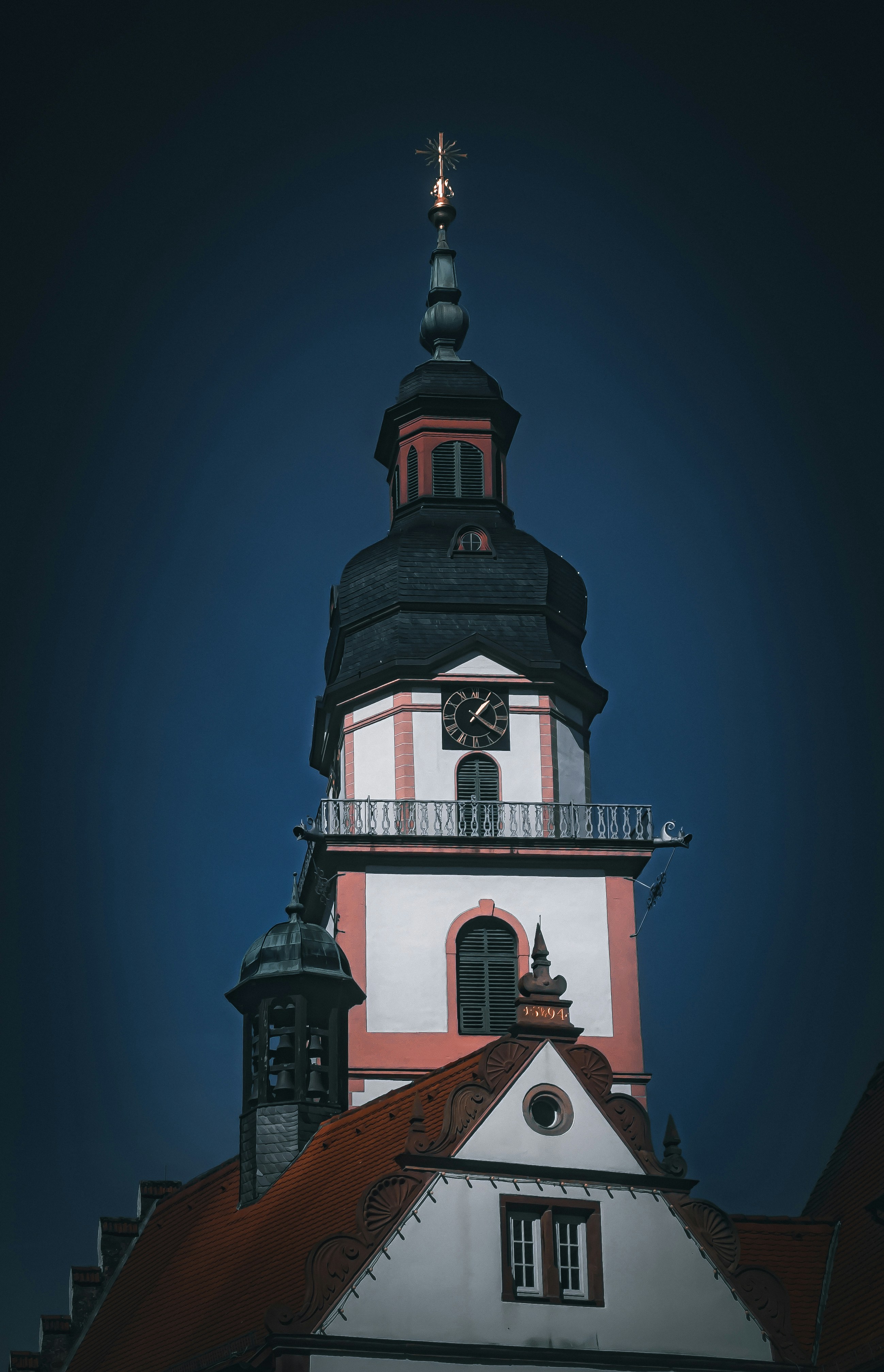 A church steeple against a dark blue sky.