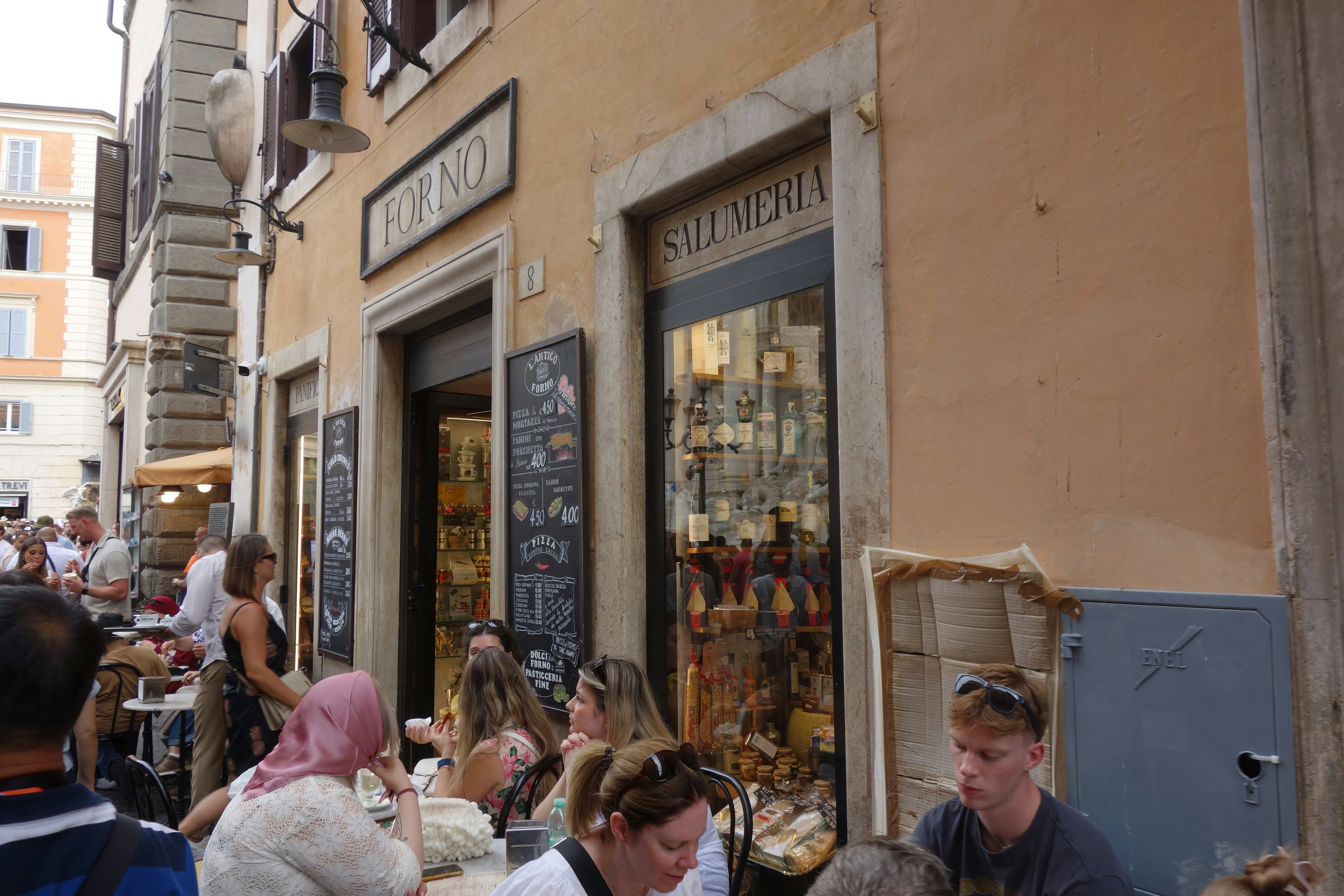 People dining outside a shop on a street