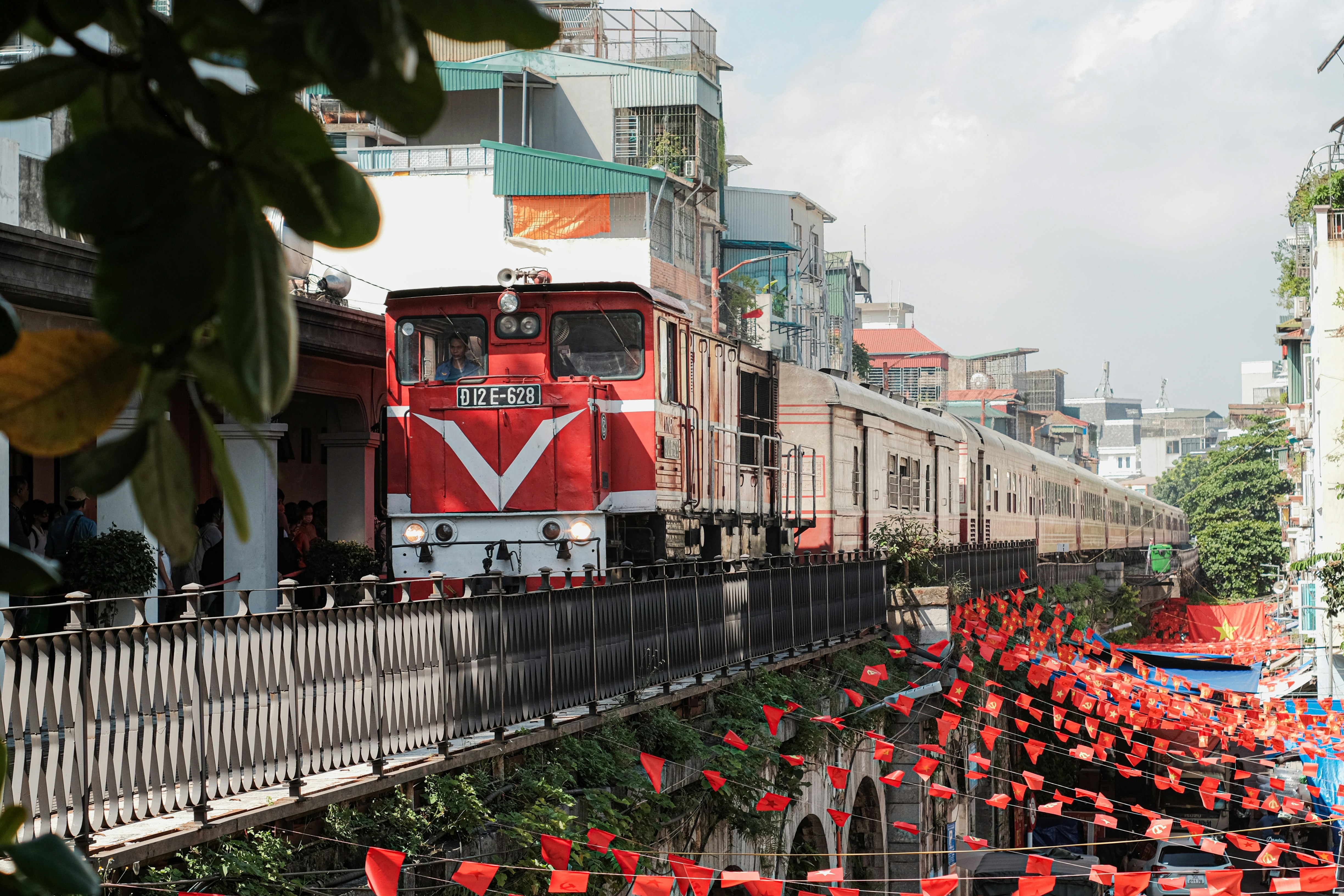 Red and white train travels along elevated tracks.