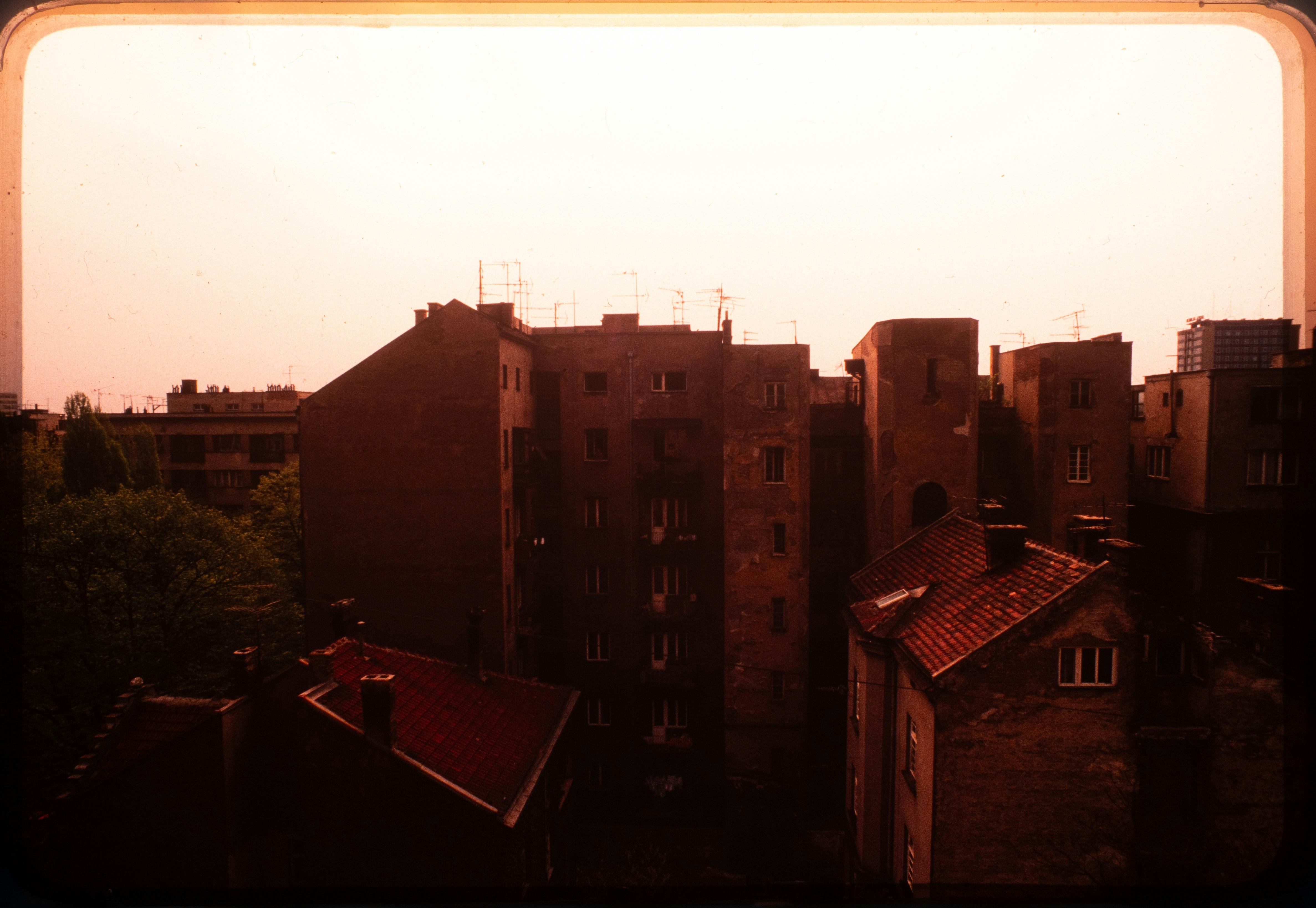 Dilapidated buildings with a warm, hazy glow, showcasing urban decay and the passage of time.