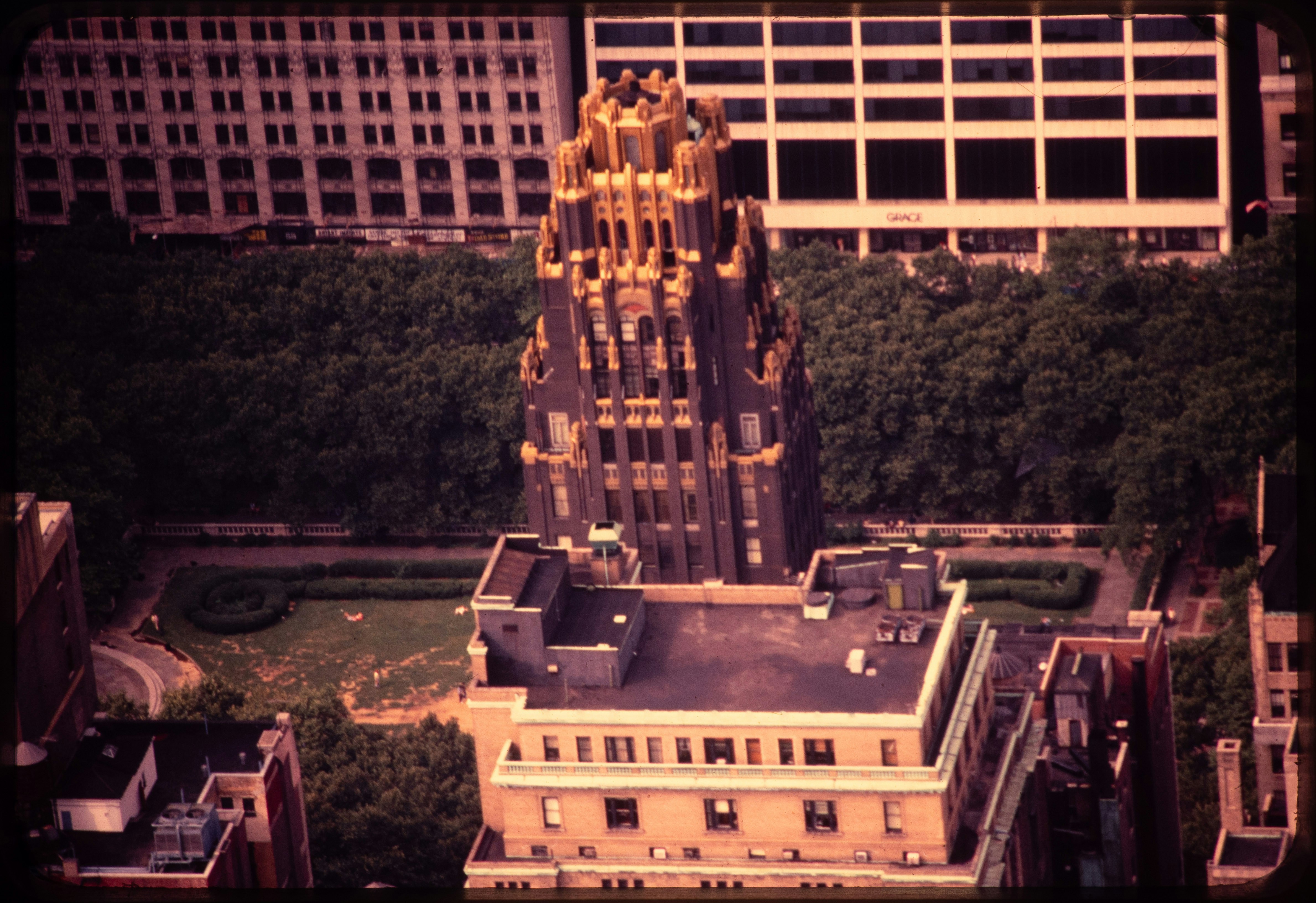 OLYMPUS DIGITAL CAMERA | Aerial view of a gothic skyscraper surrounded by trees.
