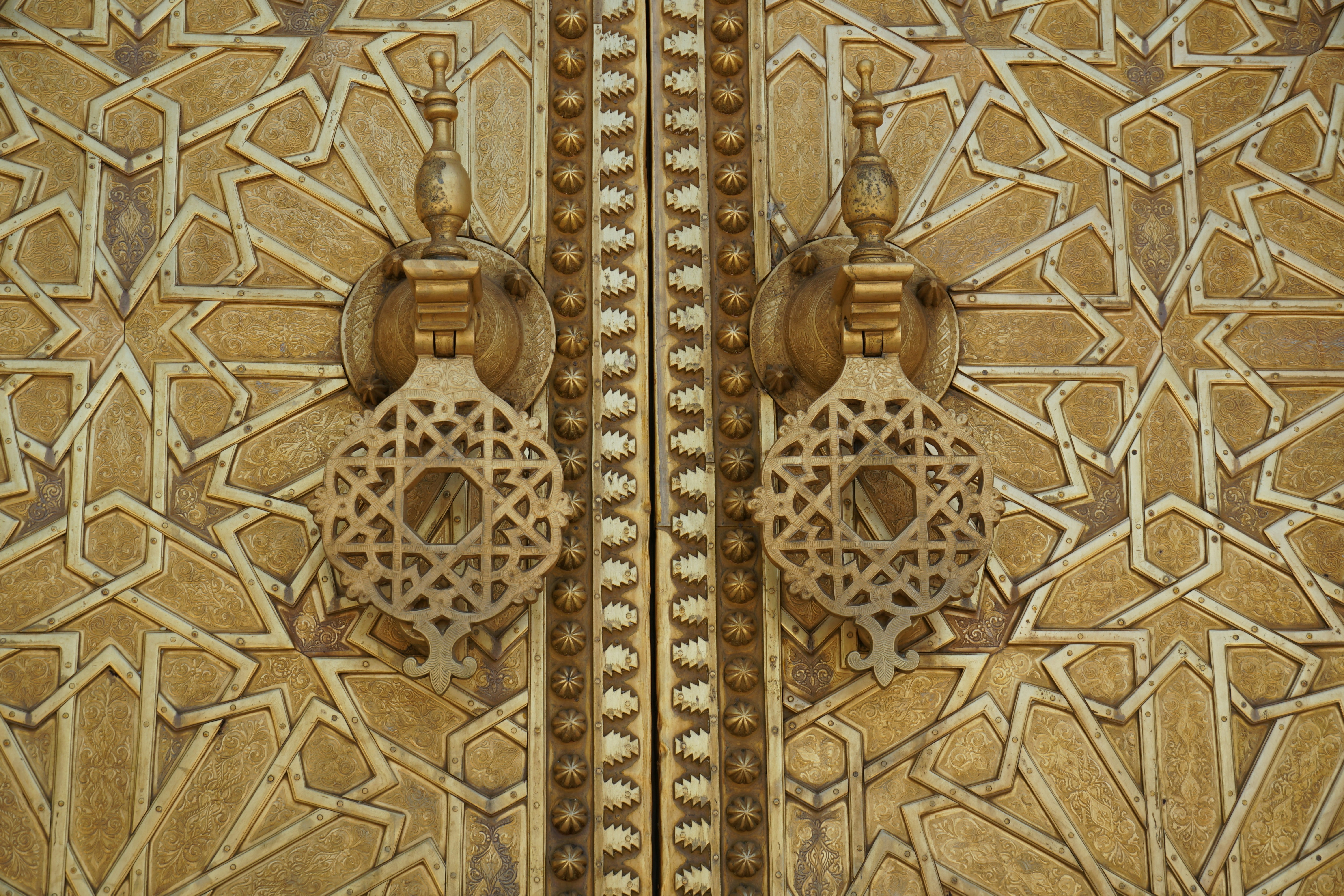 Intricate golden door with ornate handles