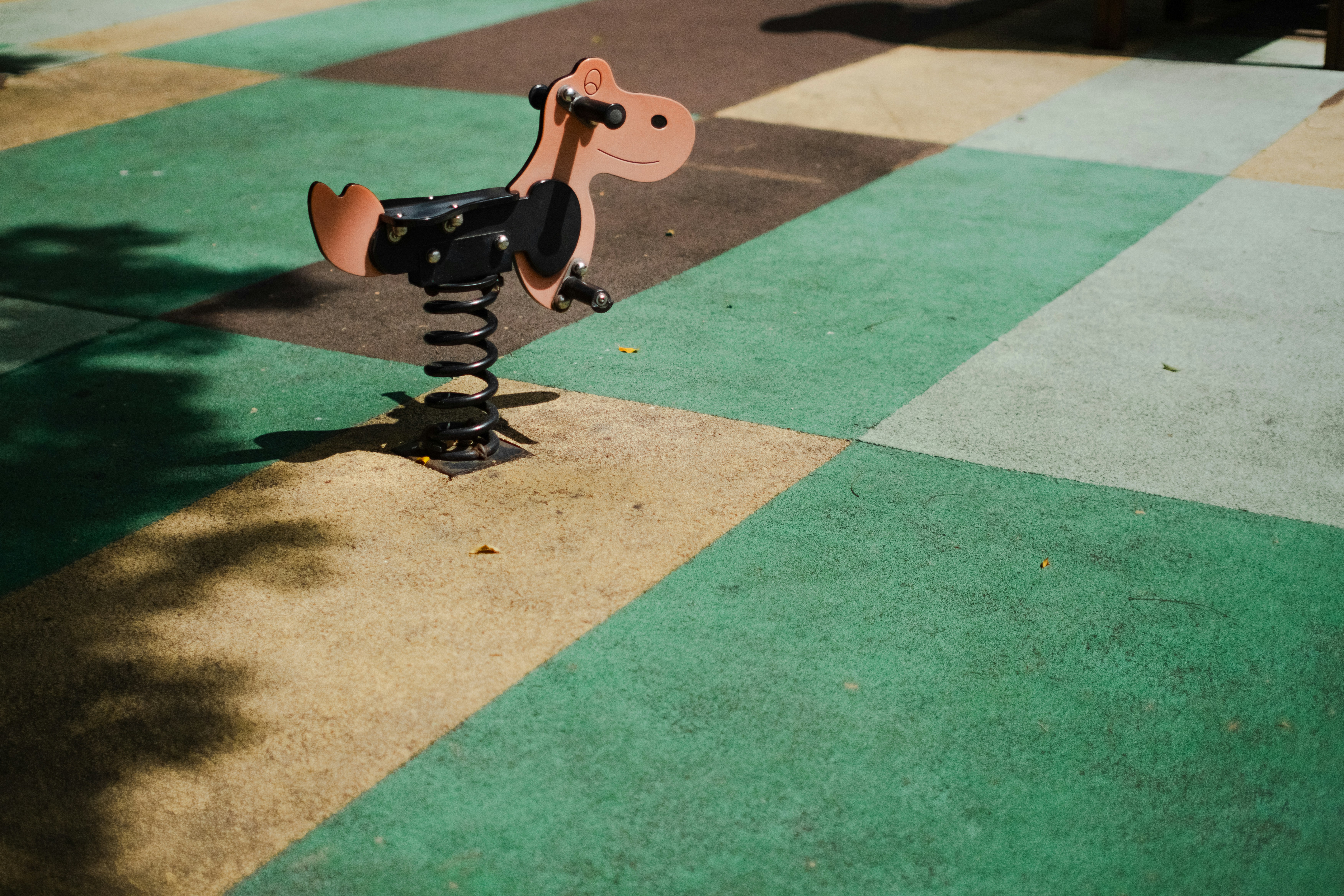 A lone spring rider on a playground.