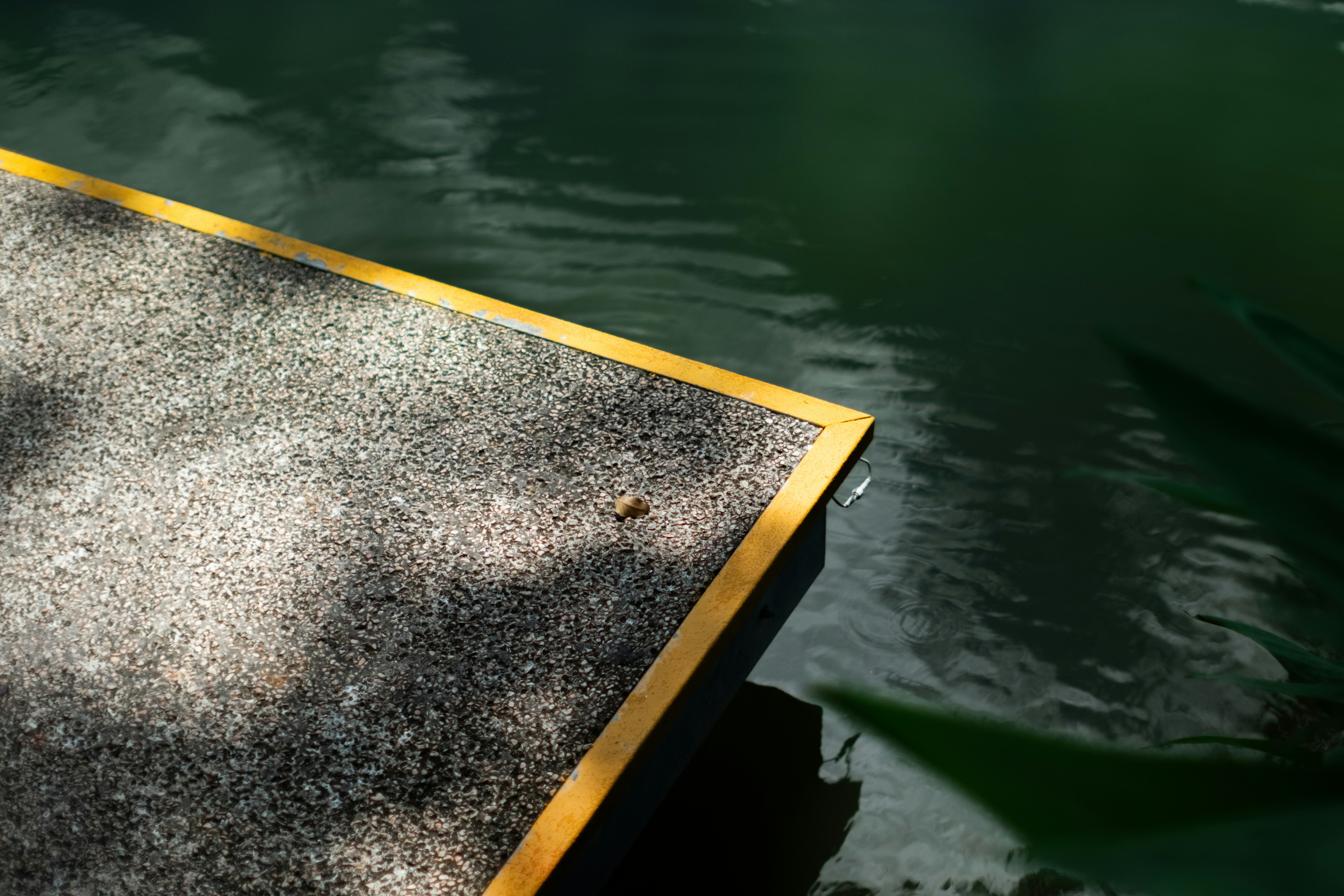 Edge of a textured platform next to dark water
