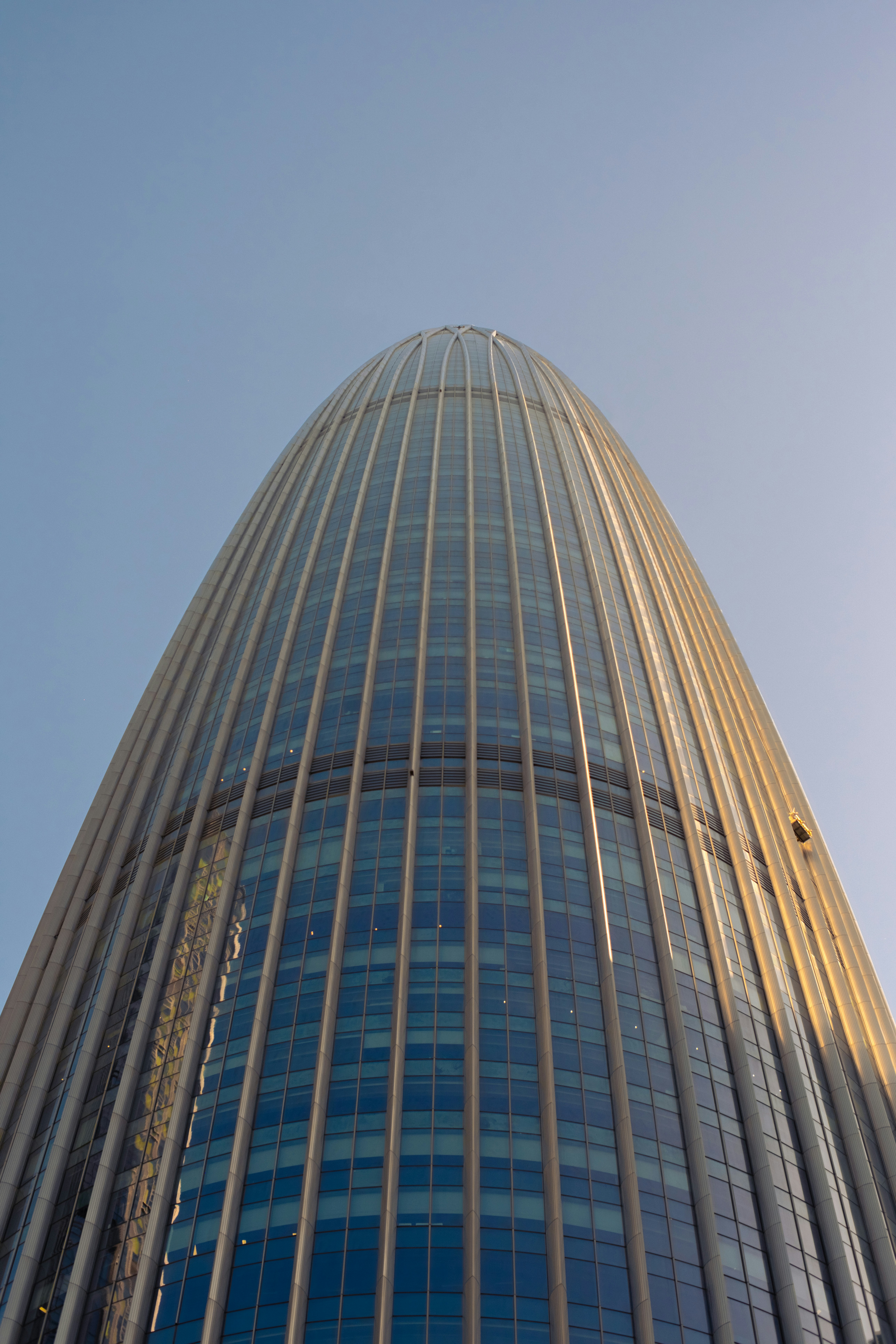 Modern skyscraper with curved glass facade against sky