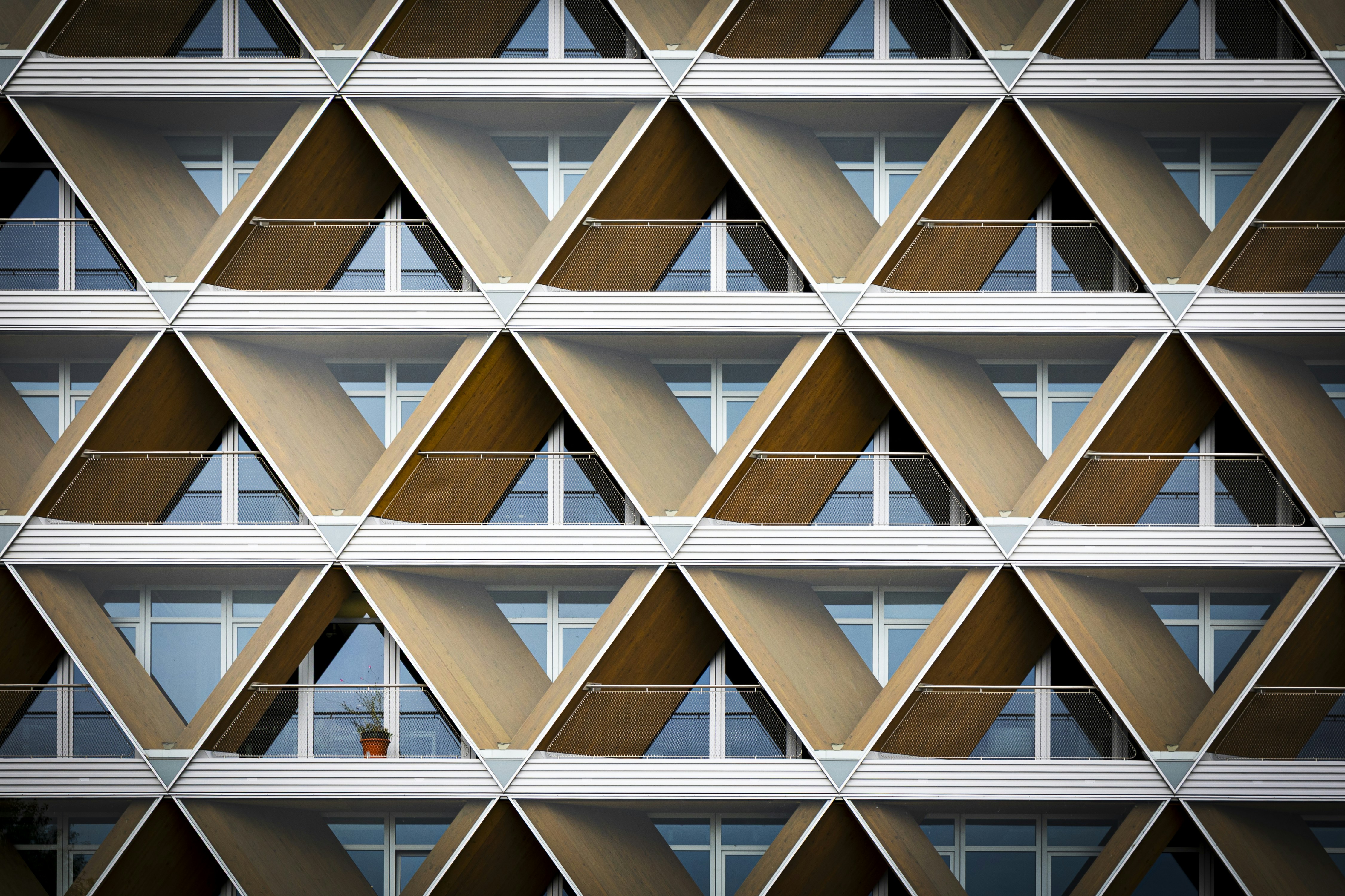 Architectural façade featuring a series of triangular patterns and balconies, creating a rhythmic visual effect.