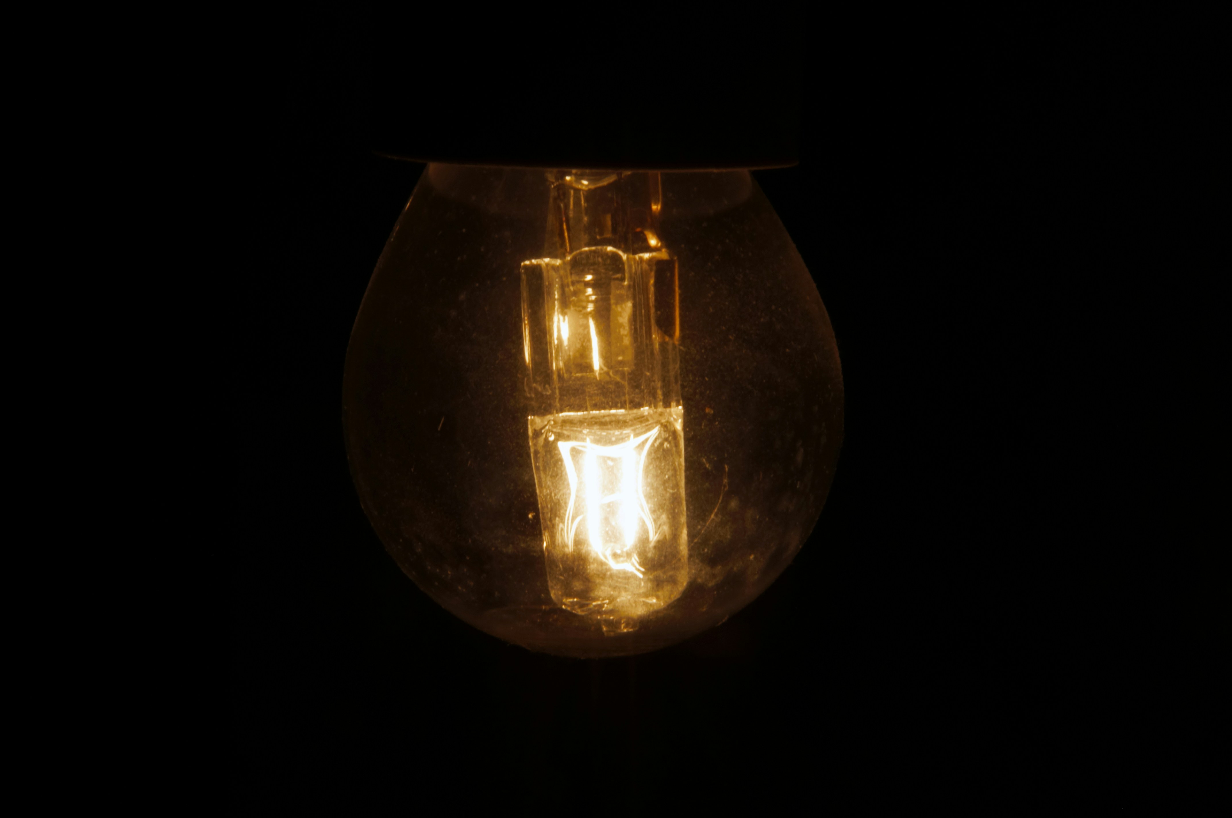 a light bulb. i think it looks cool :0 | Close-up of a glowing incandescent light bulb filament.