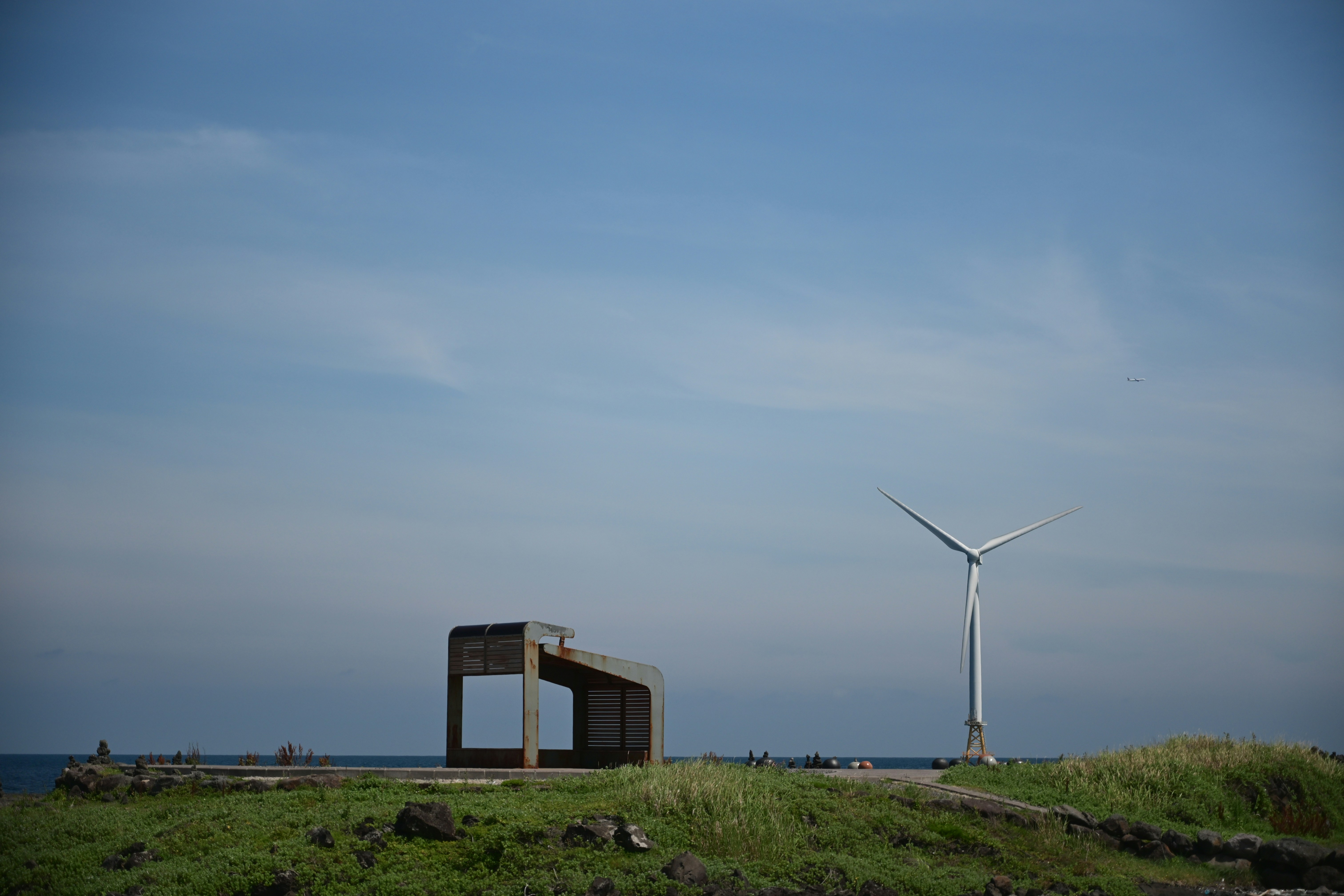Wind turbine and structure on grassy coast