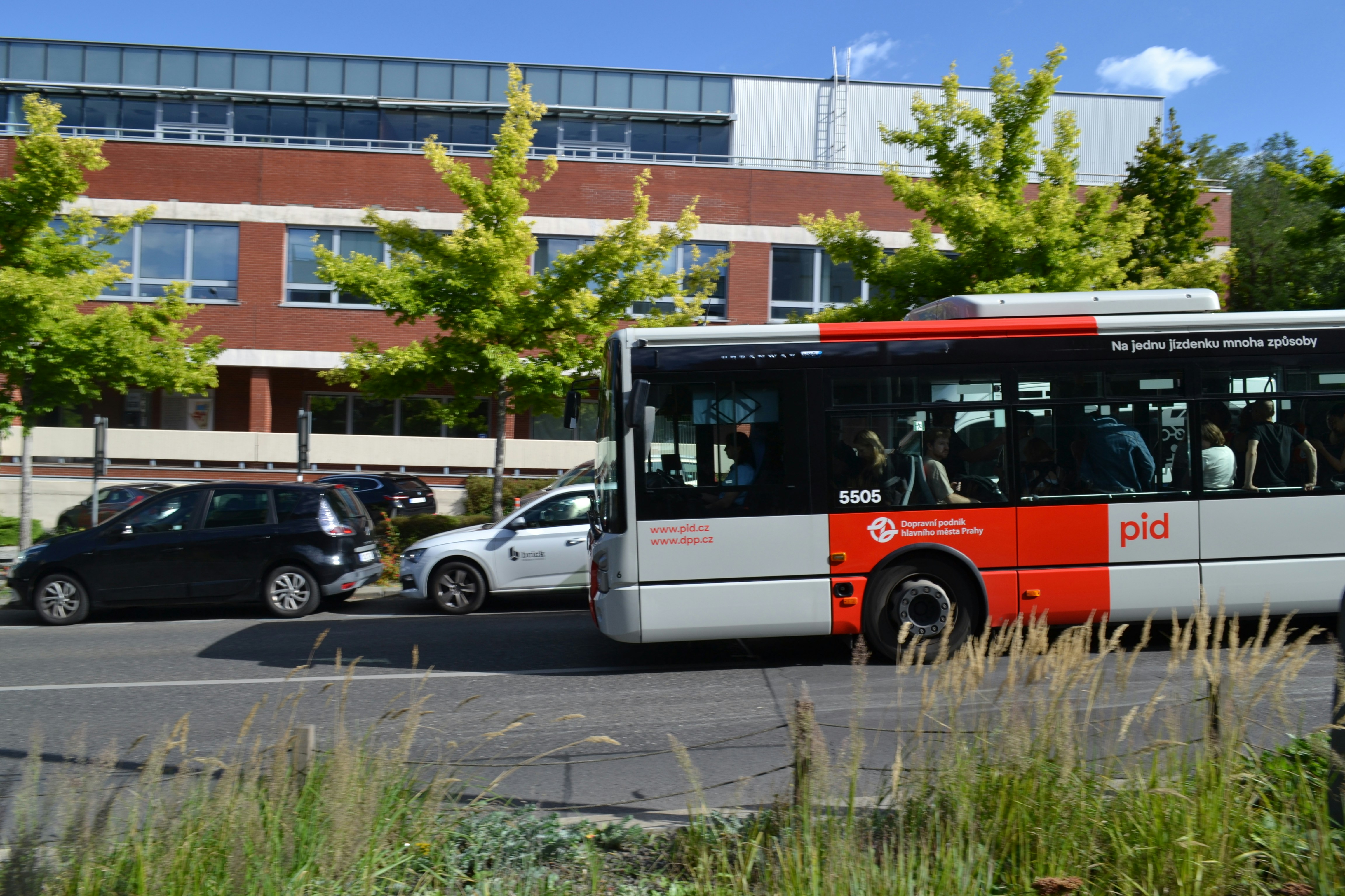 Bus and cars on a street near a building