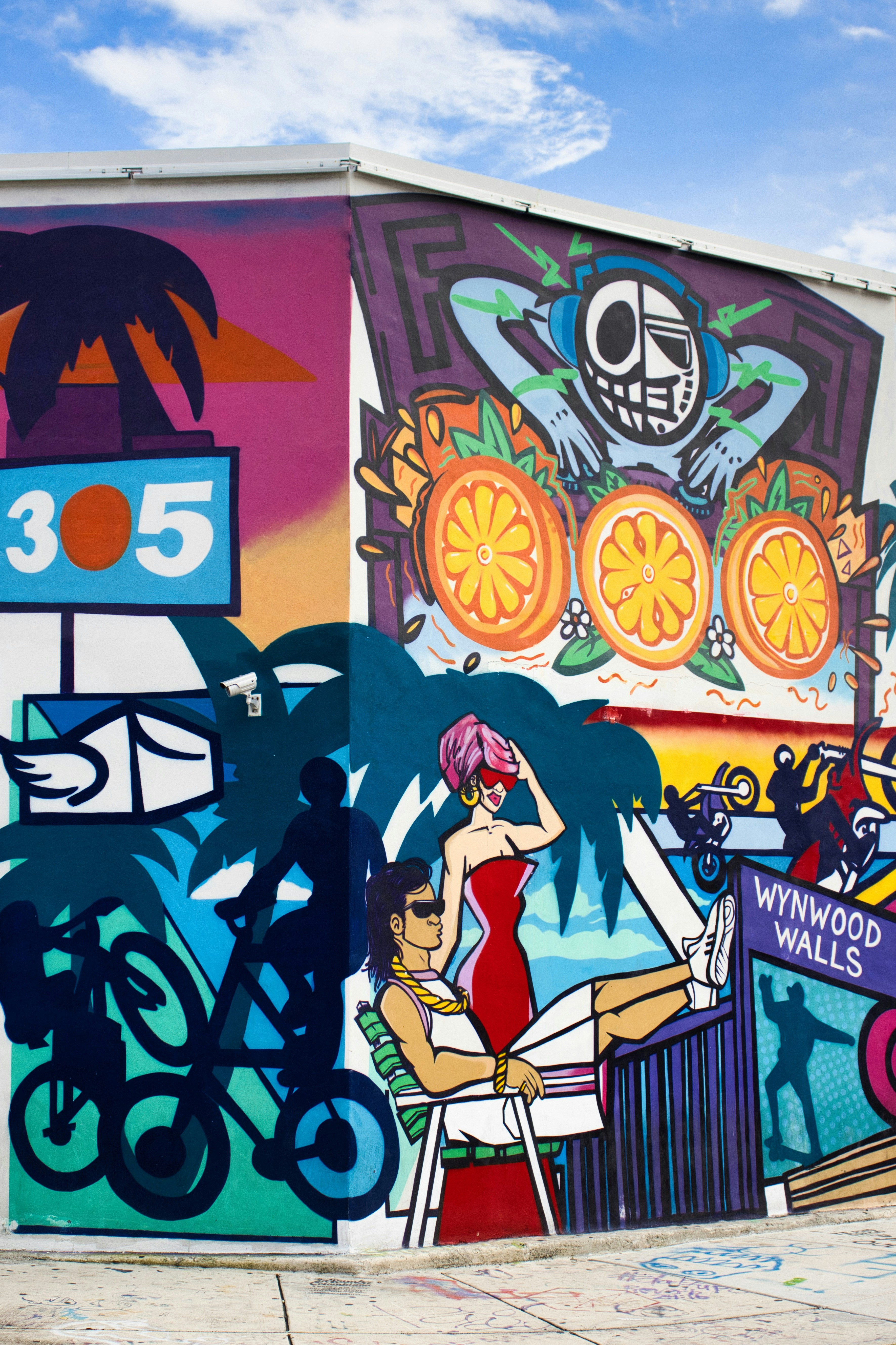 Vibrant wynwood walls mural with colorful figures and palm trees.
