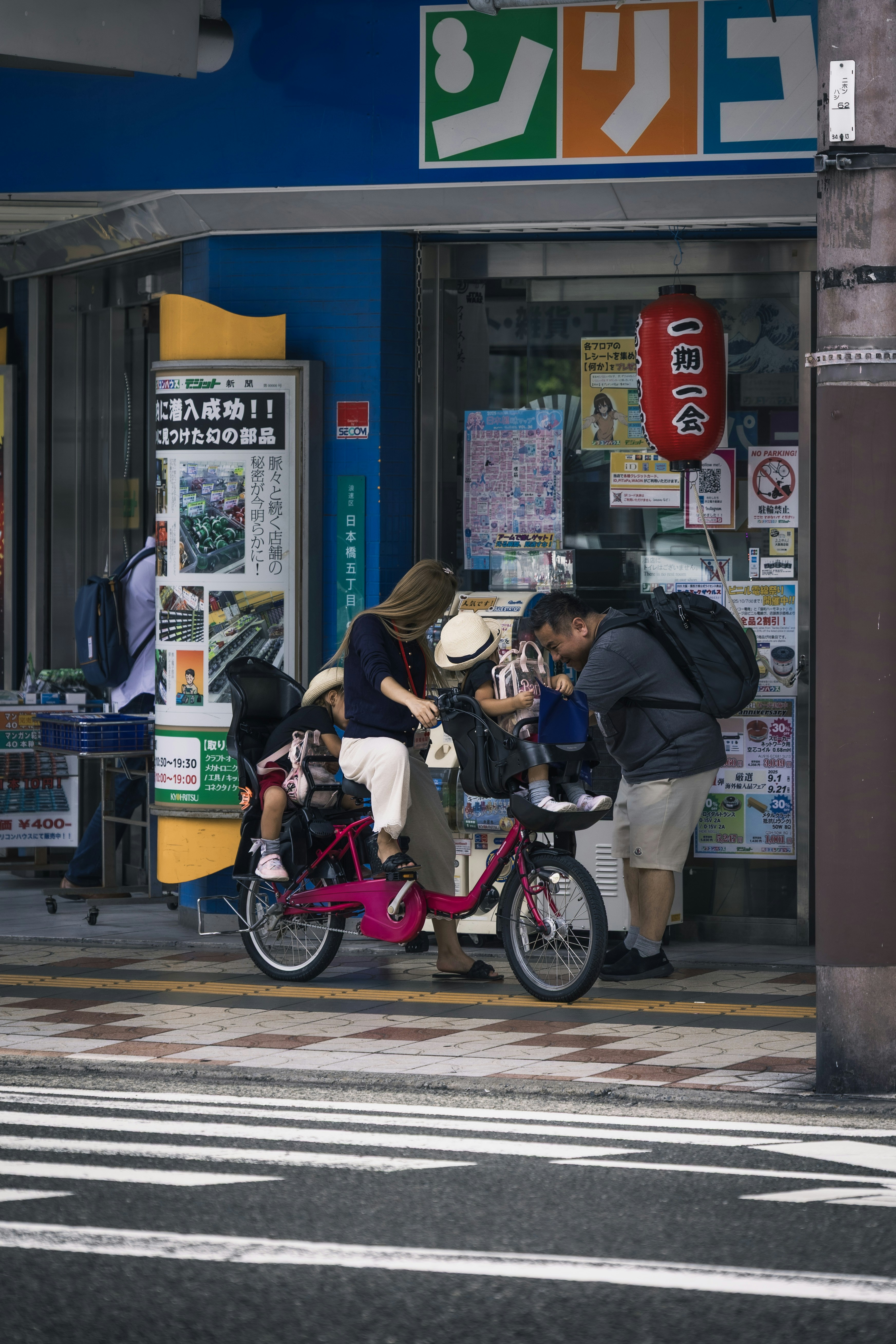 Family on a Pink Tandem Outside a Japanese Storefront