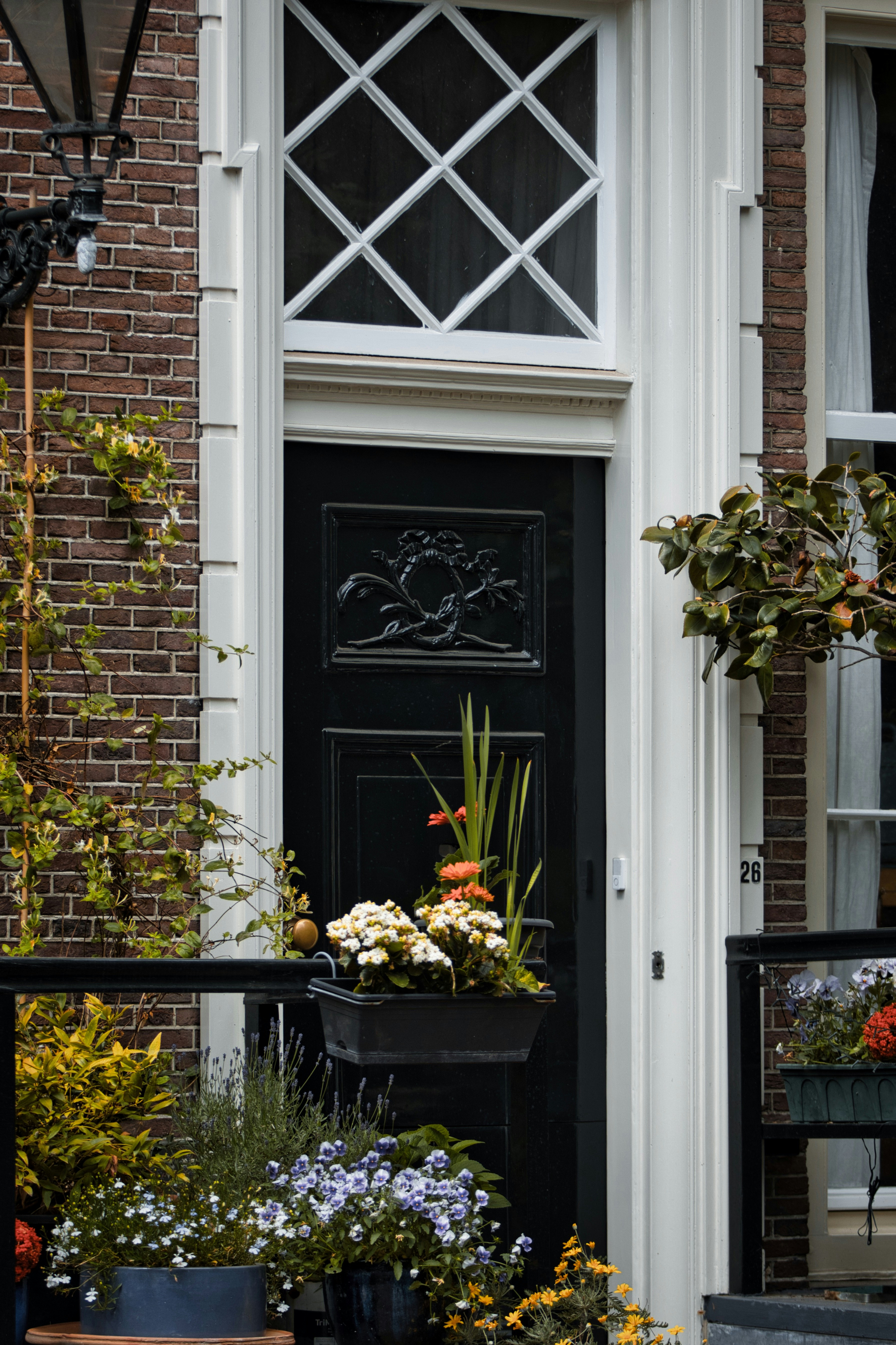 Ornate Doorway in Bloom: A Brick Home’s Quiet Welcome