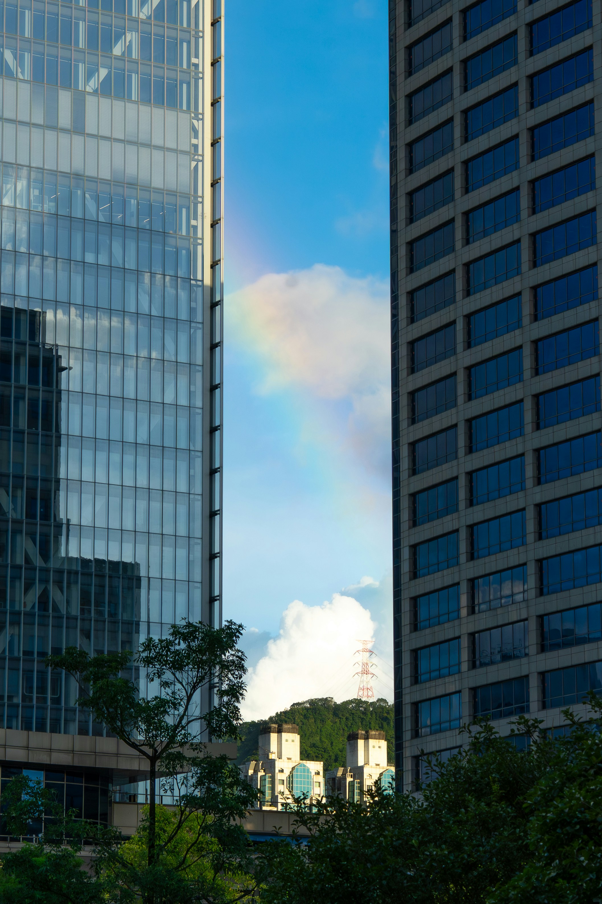 Rainbow visible between two modern buildings.