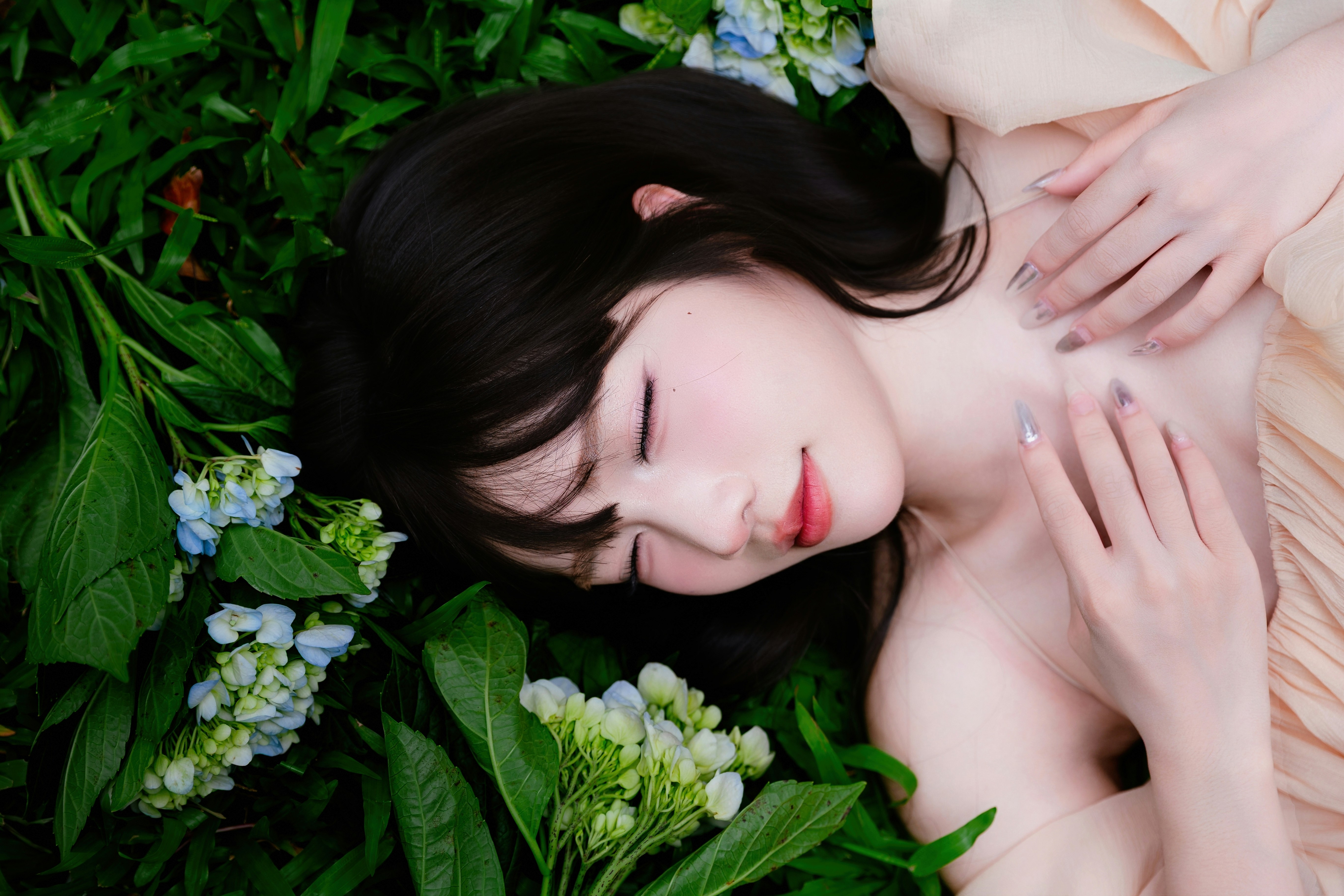 A serene scene featuring a young woman resting among lush greenery and delicate flowers, embodying tranquility and connection with nature.
