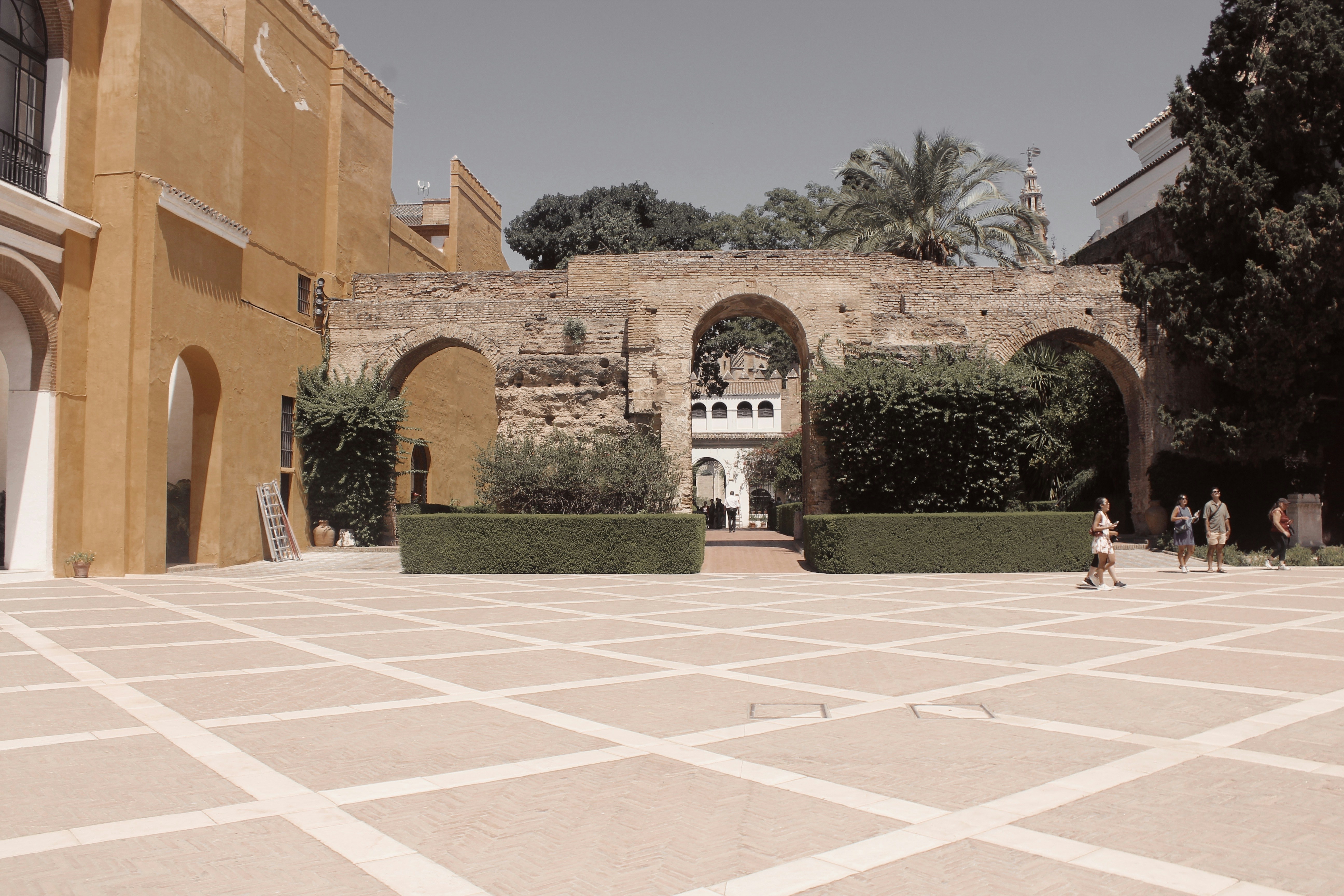 Patio Real Alcázar en Sevilla España | Courtyard with historic arches and manicured hedges