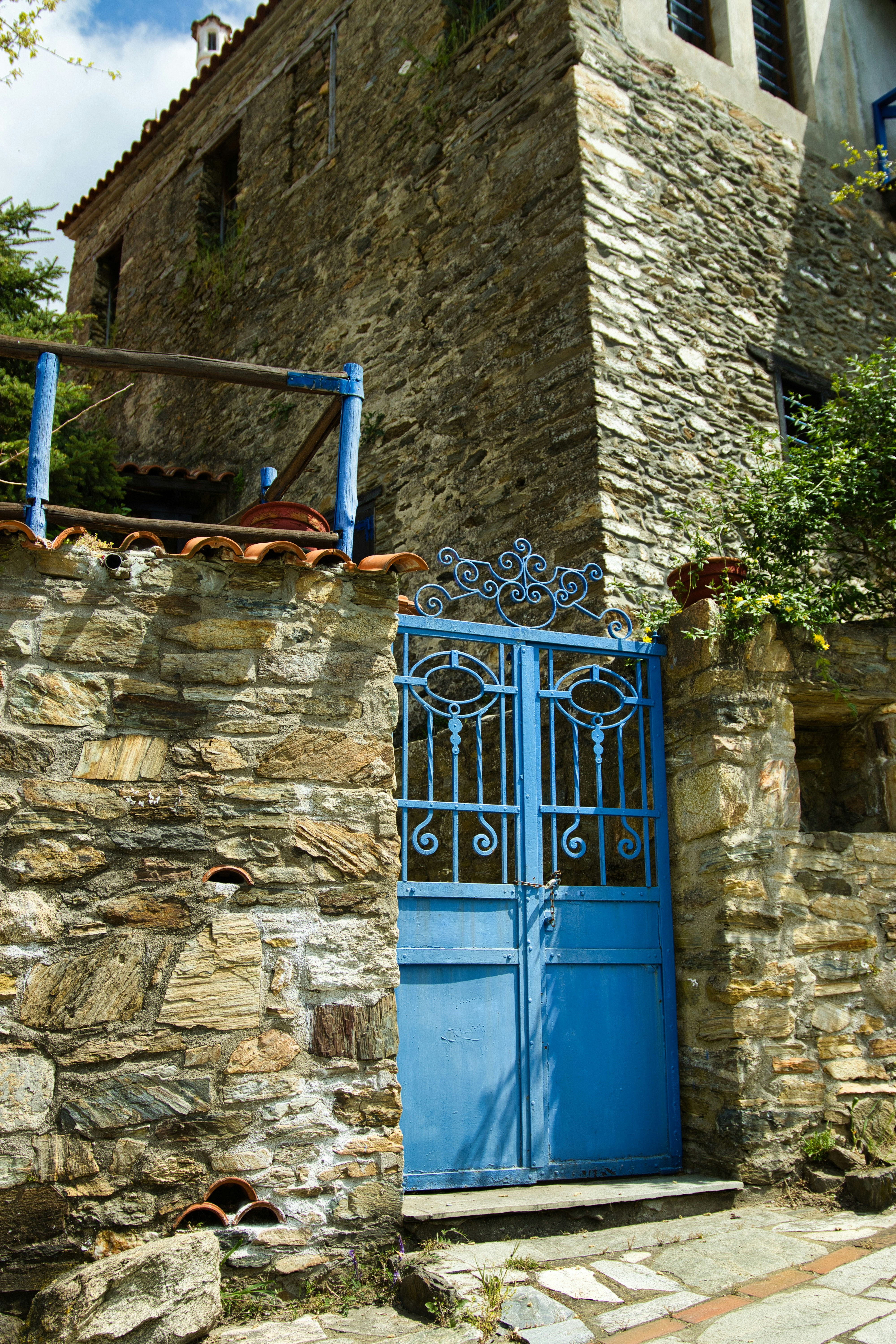 Azure Gateways: A Weathered Stone Façade Framed in Blue Iron
