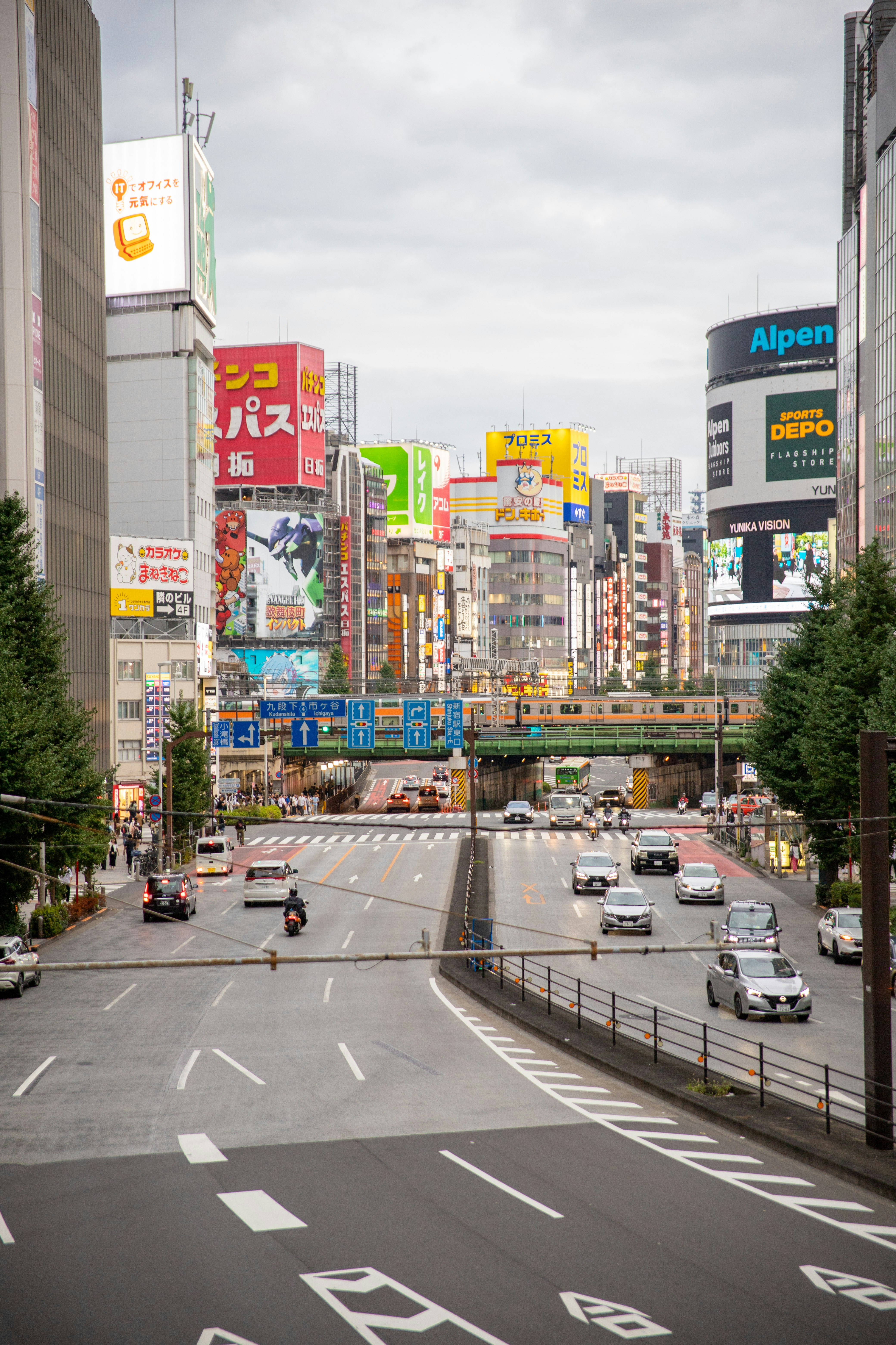 Street view of Shinjuku with billboards and traffic in Tokyo, Japan. | Busy street with cars and buildings in tokyo.