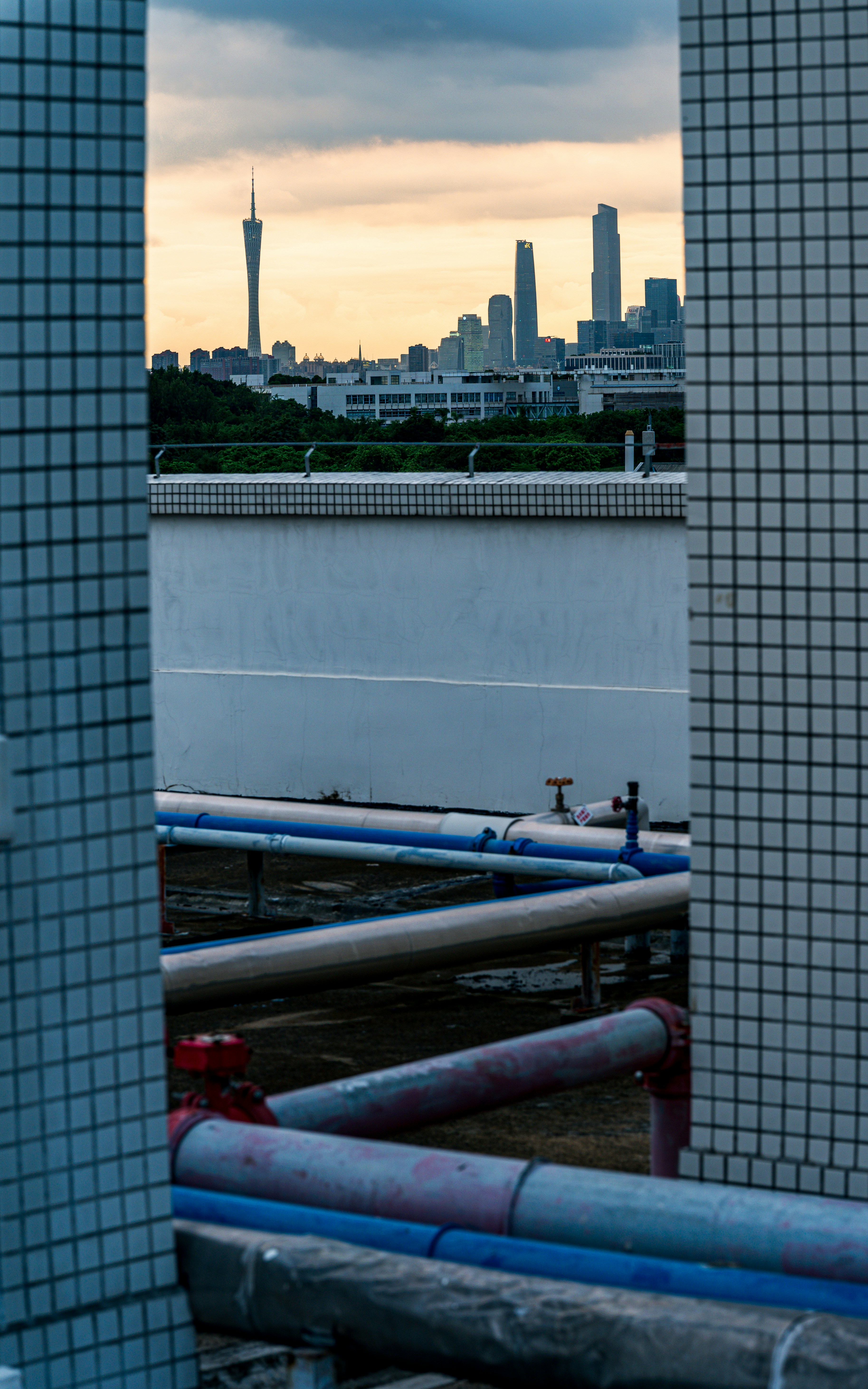 Rooftop Pipes Framing a City Silhouette at Dusk