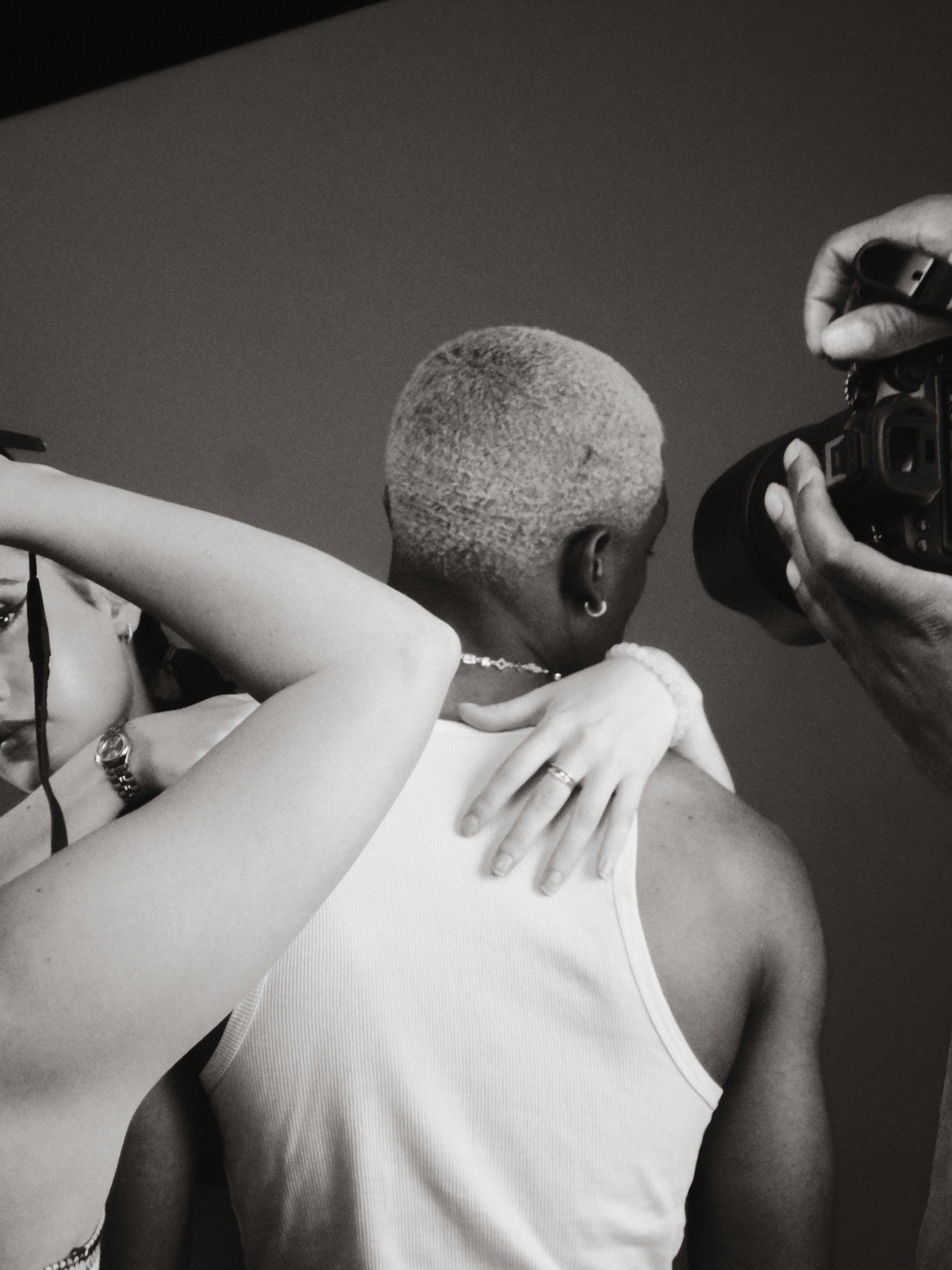 Models posing for a photographer with a camera.