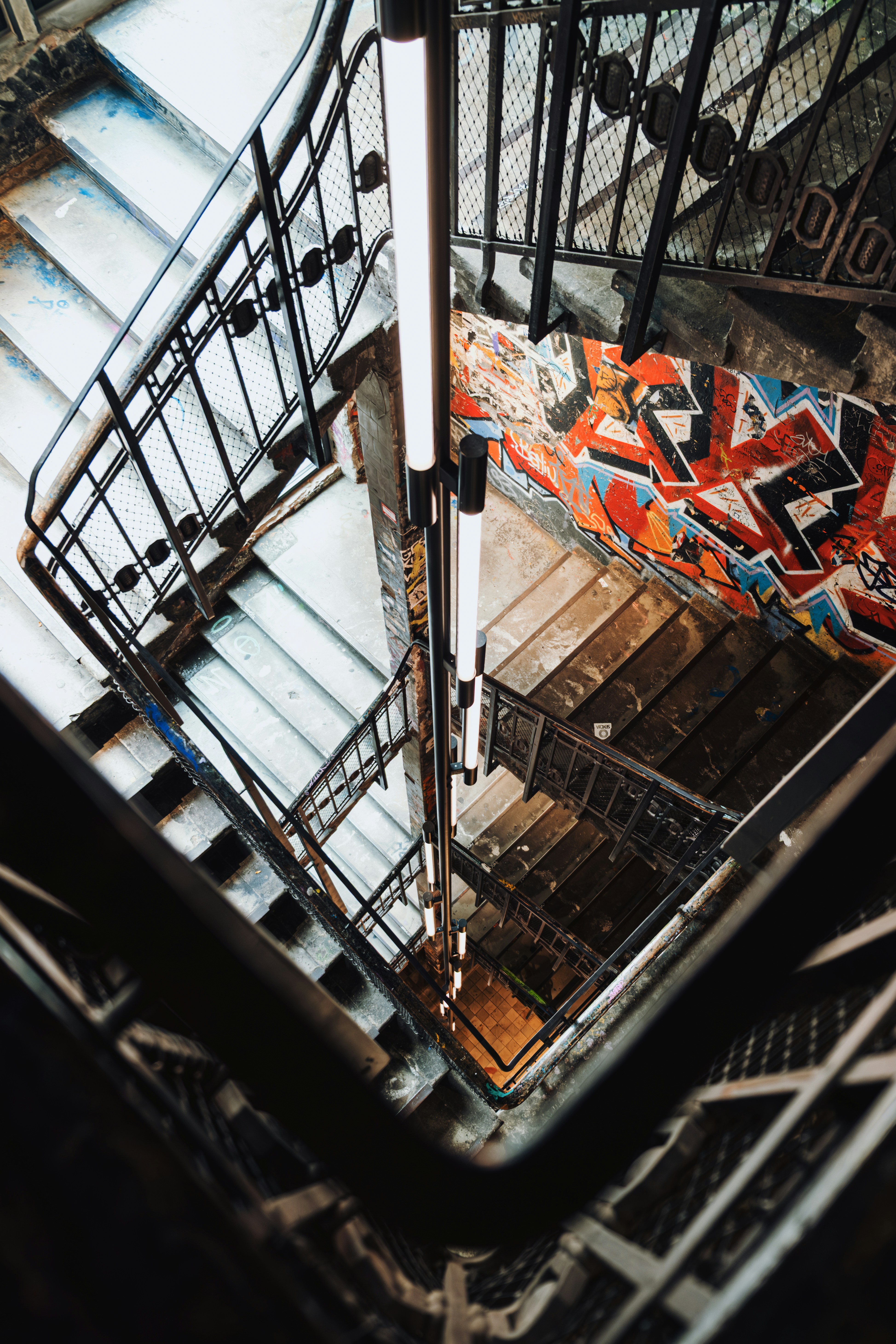 Looking down a spiral staircase with graffiti art