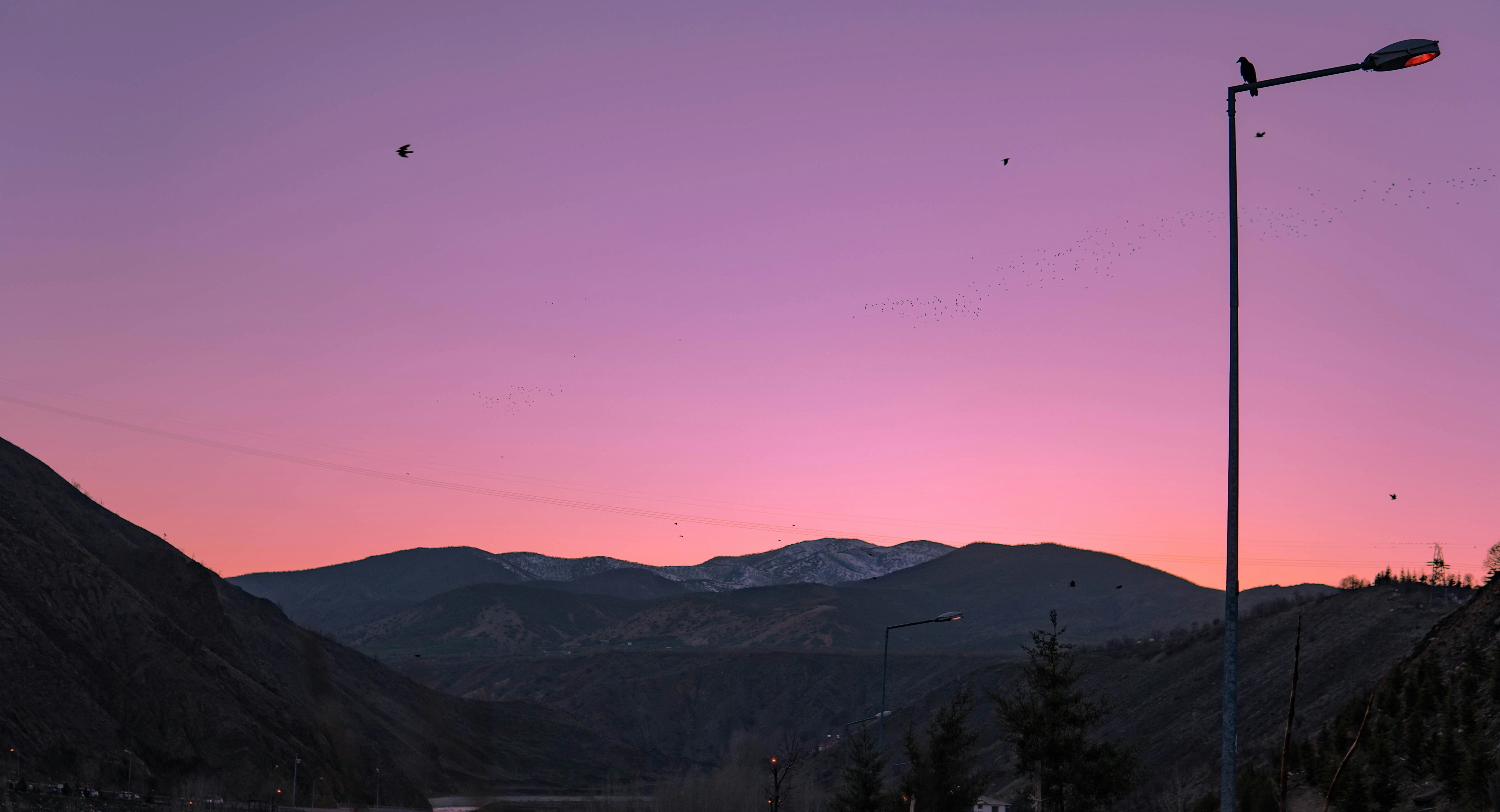 街灯で夕暮れ時の山の上の紫色の空の写真 – Unsplashの背景の無料画像