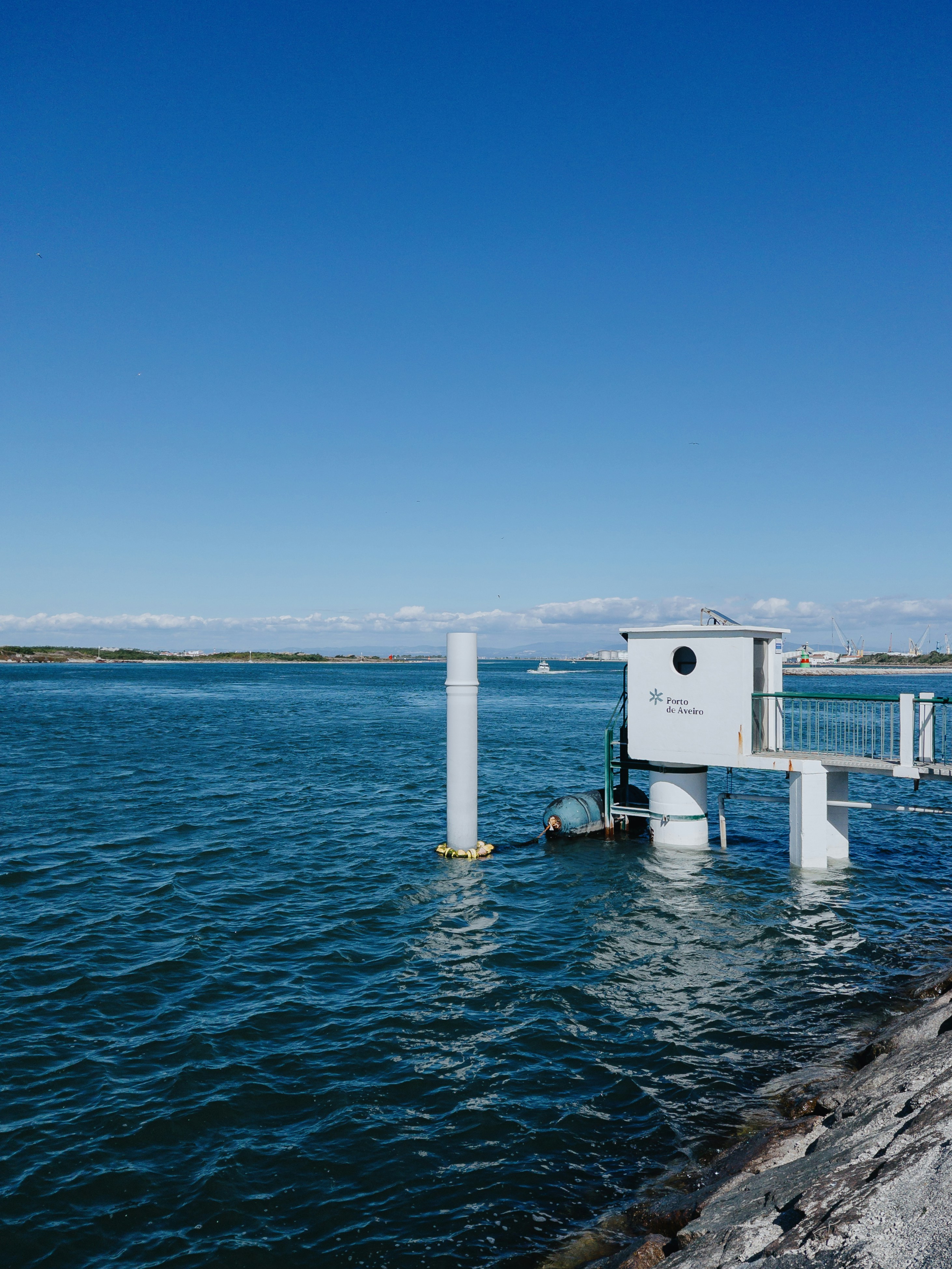 White structure on water under a clear blue sky.