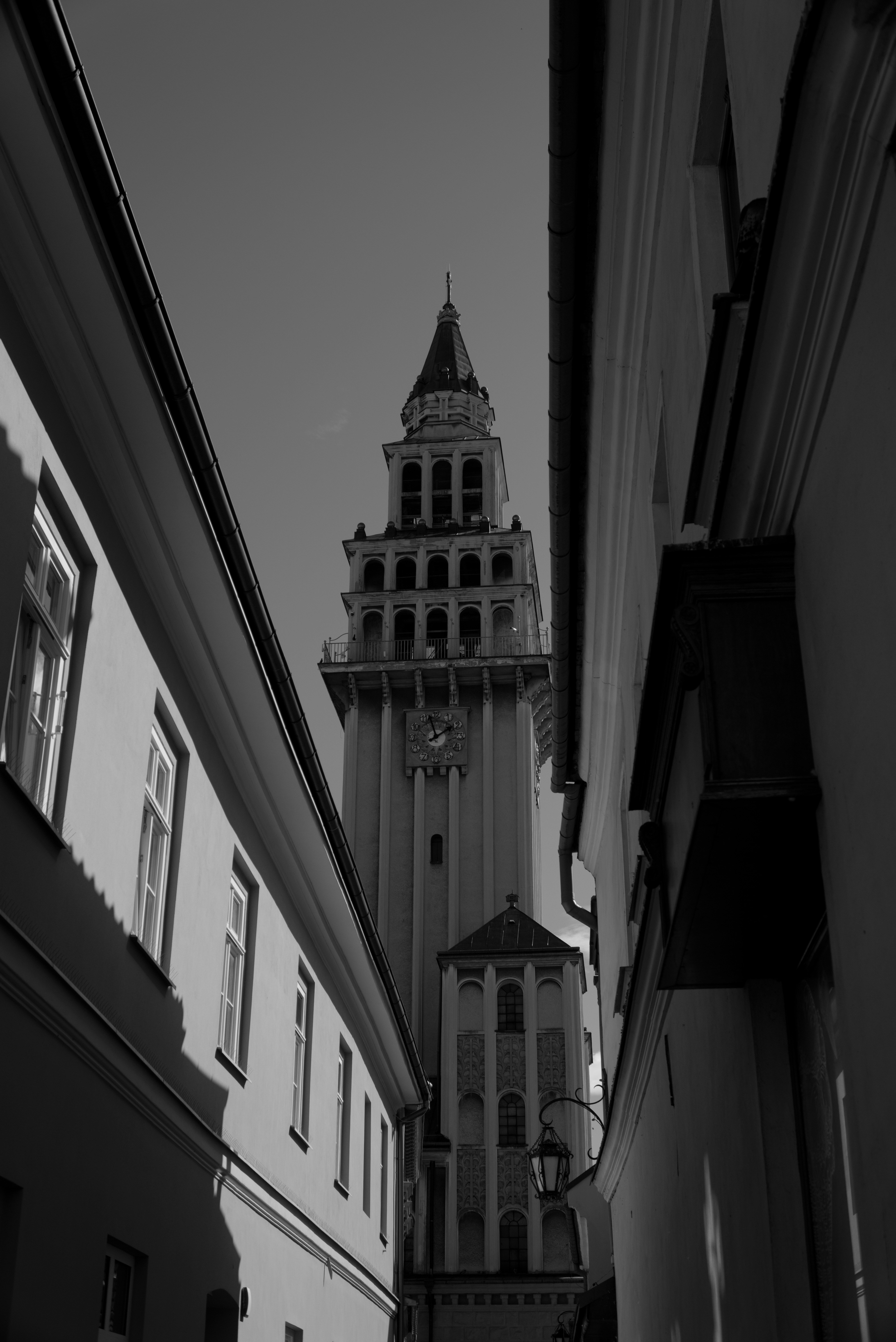 Tall clock tower viewed between buildings