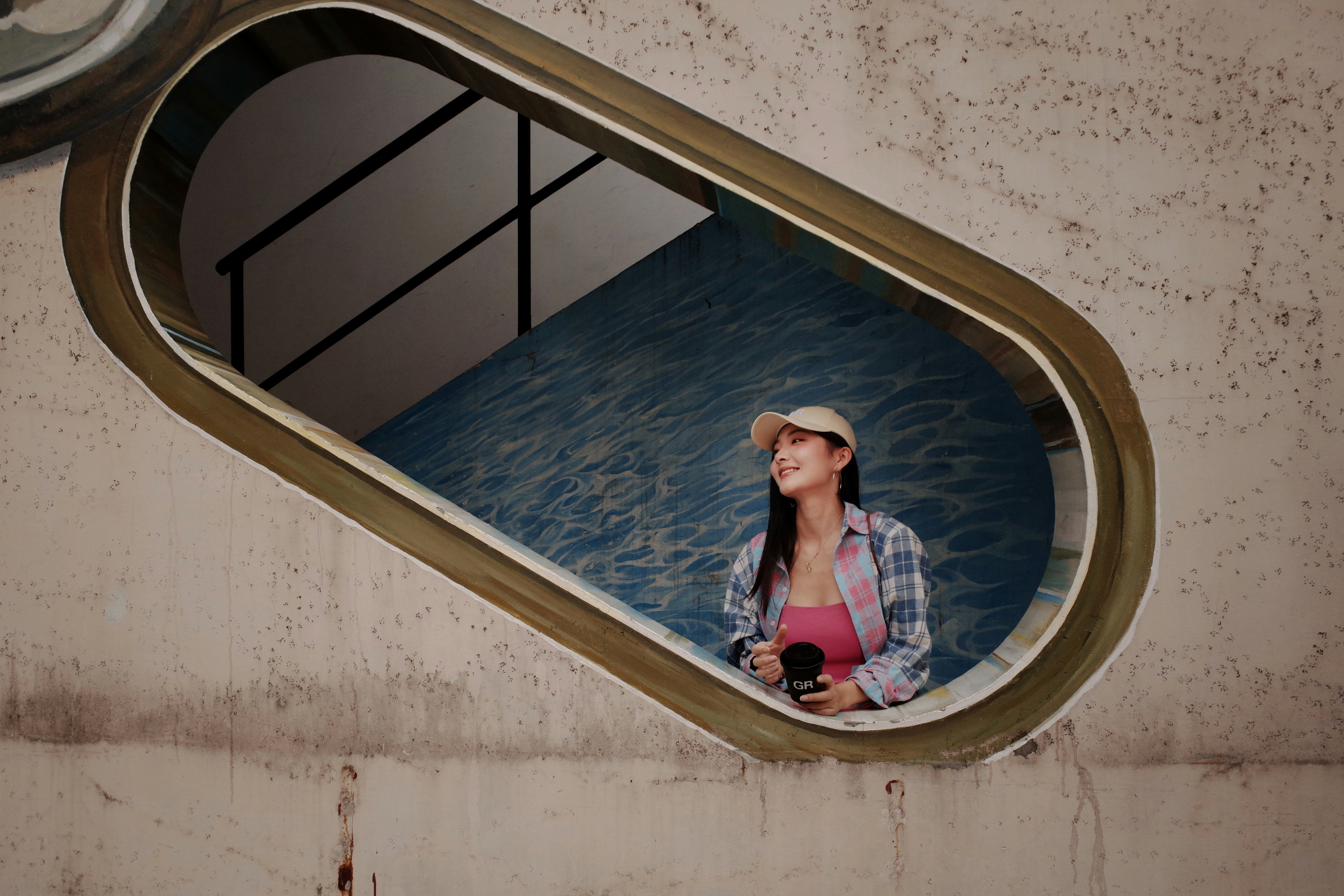 Young woman in hat looks out window