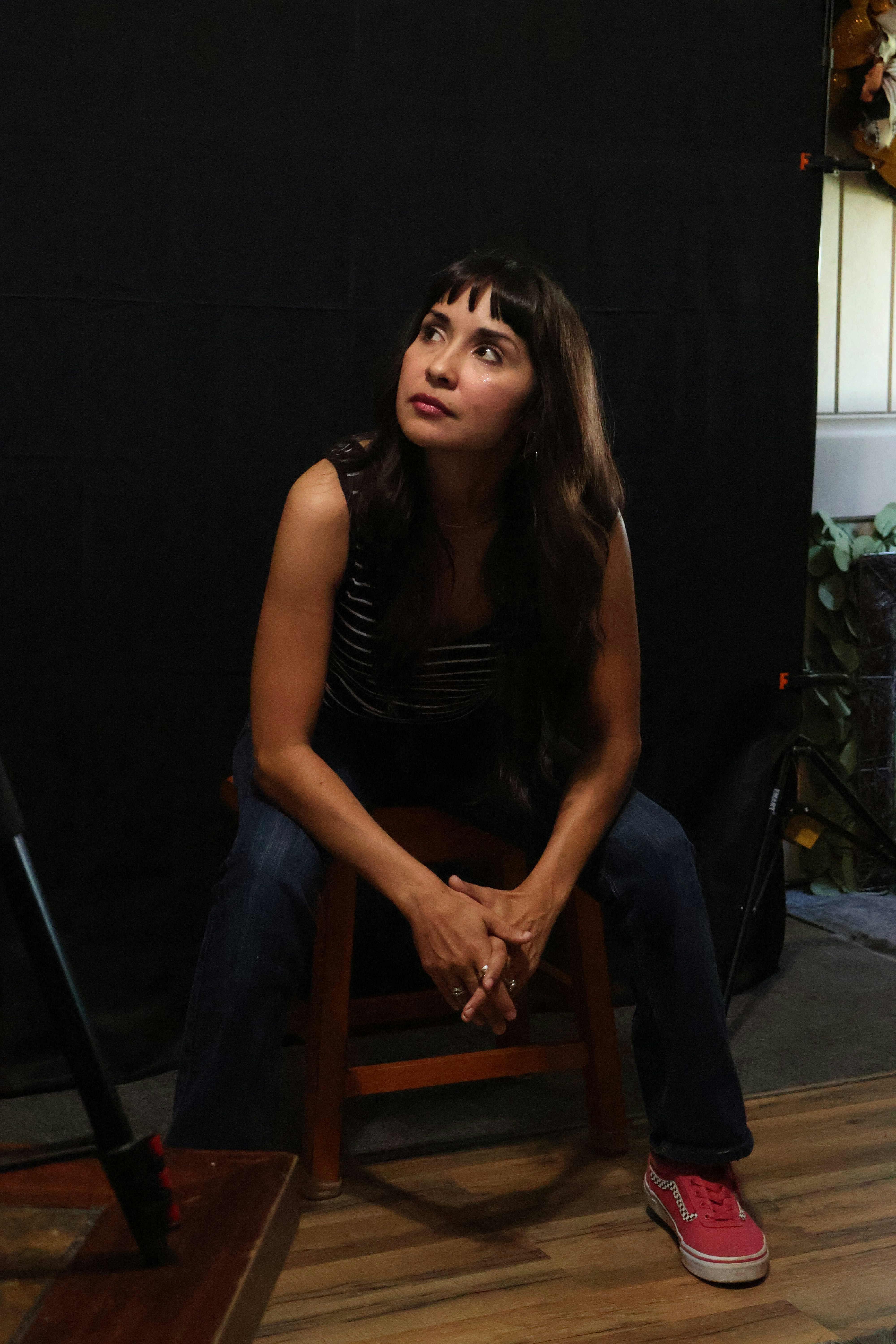 Woman sitting on stool looking up