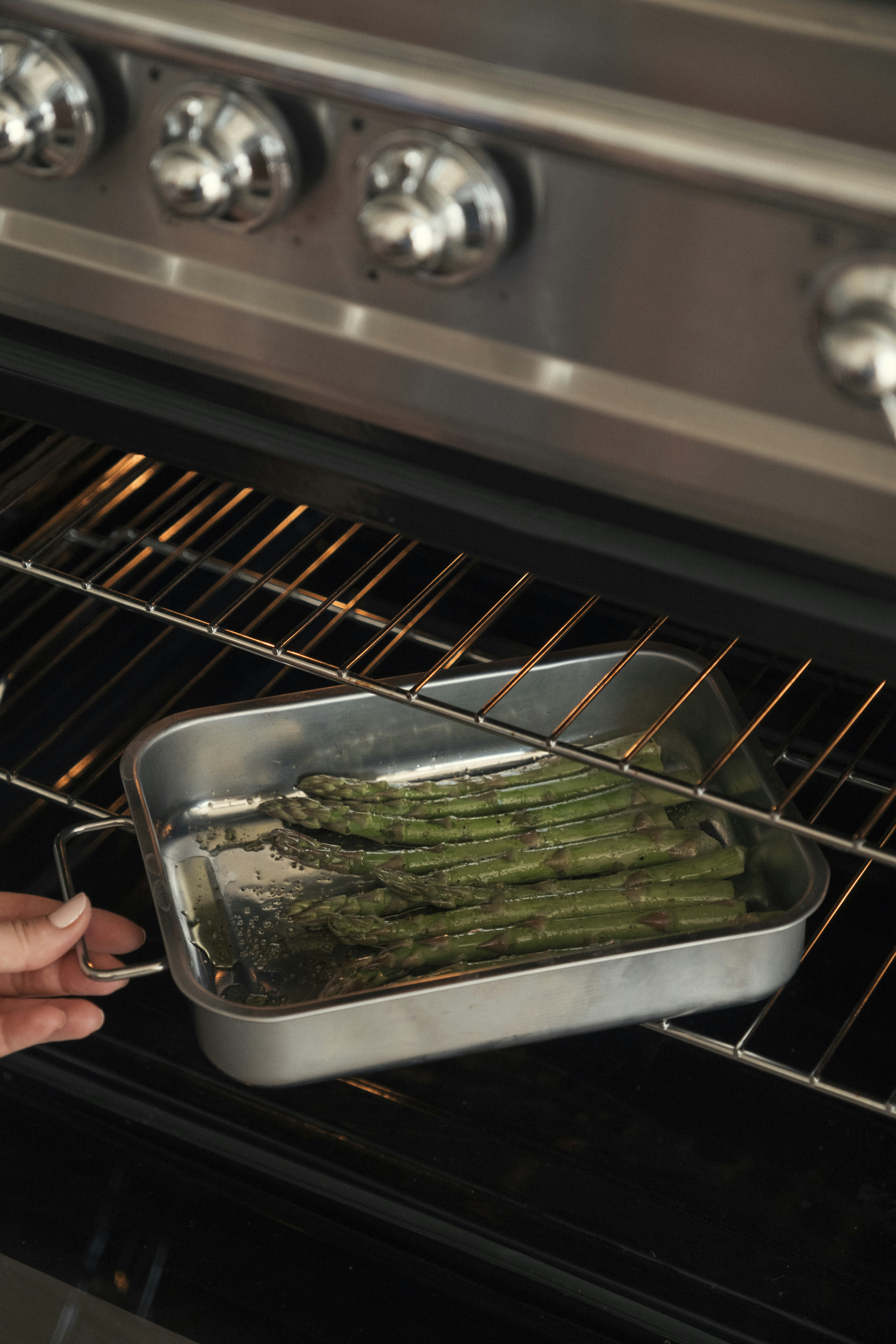 Emerald spears slide into the oven’s amber glow