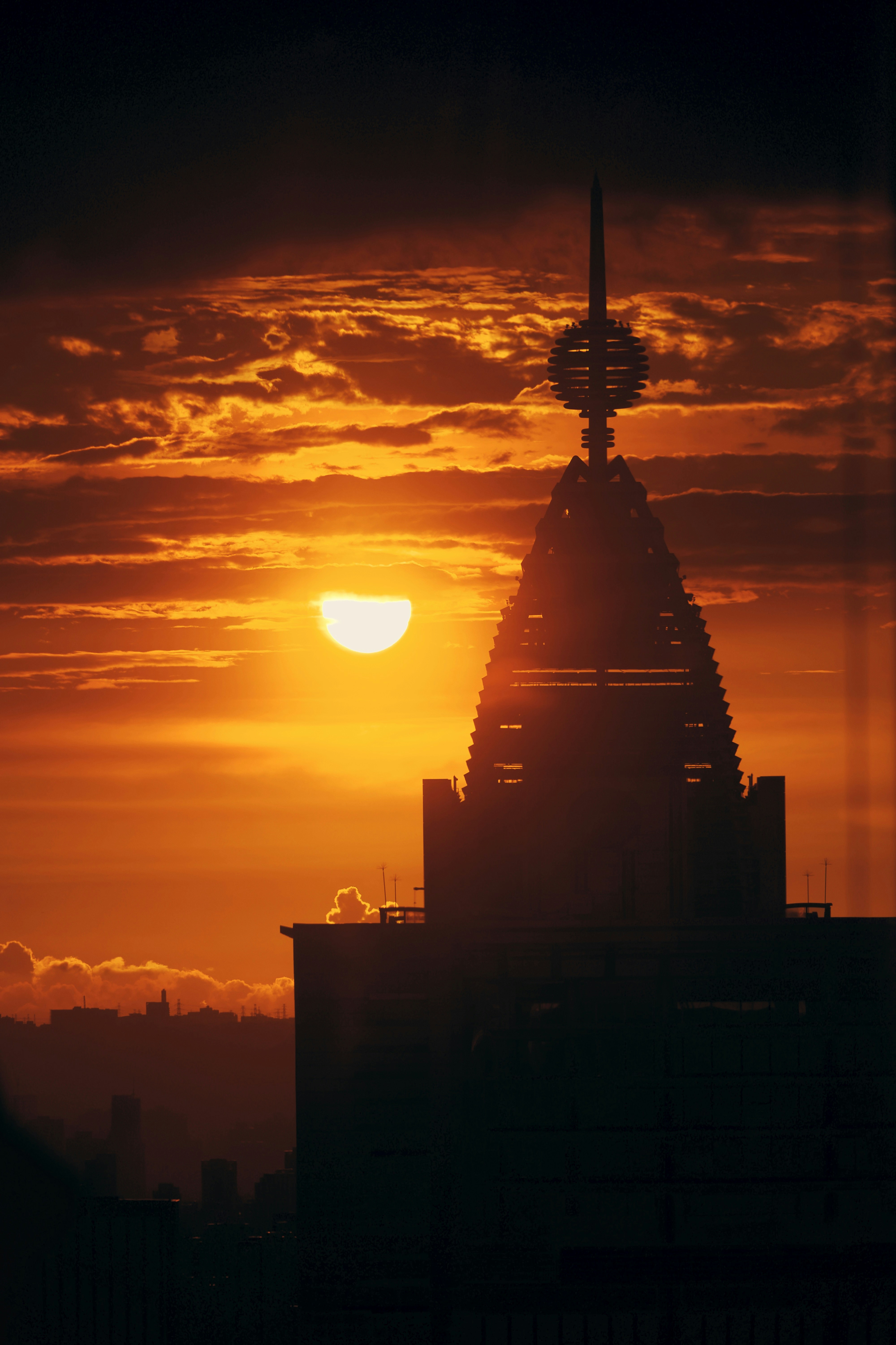 Silhouette of a building against a dramatic sunset sky.