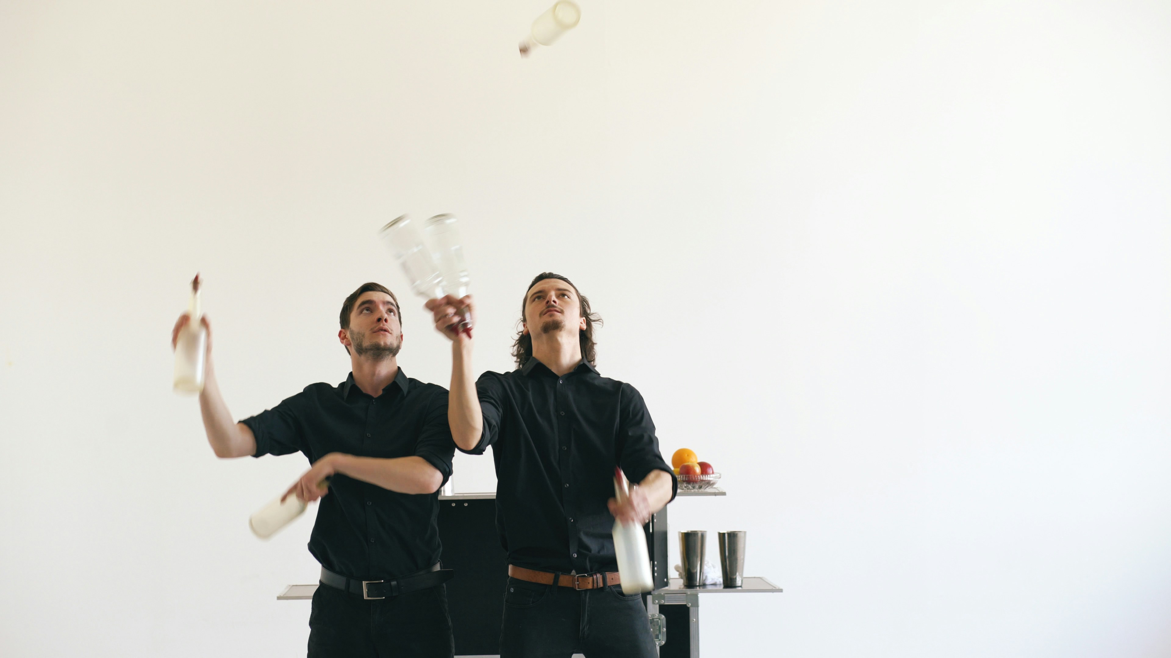 Two bartenders juggling bottles against a white background photo – Free ...