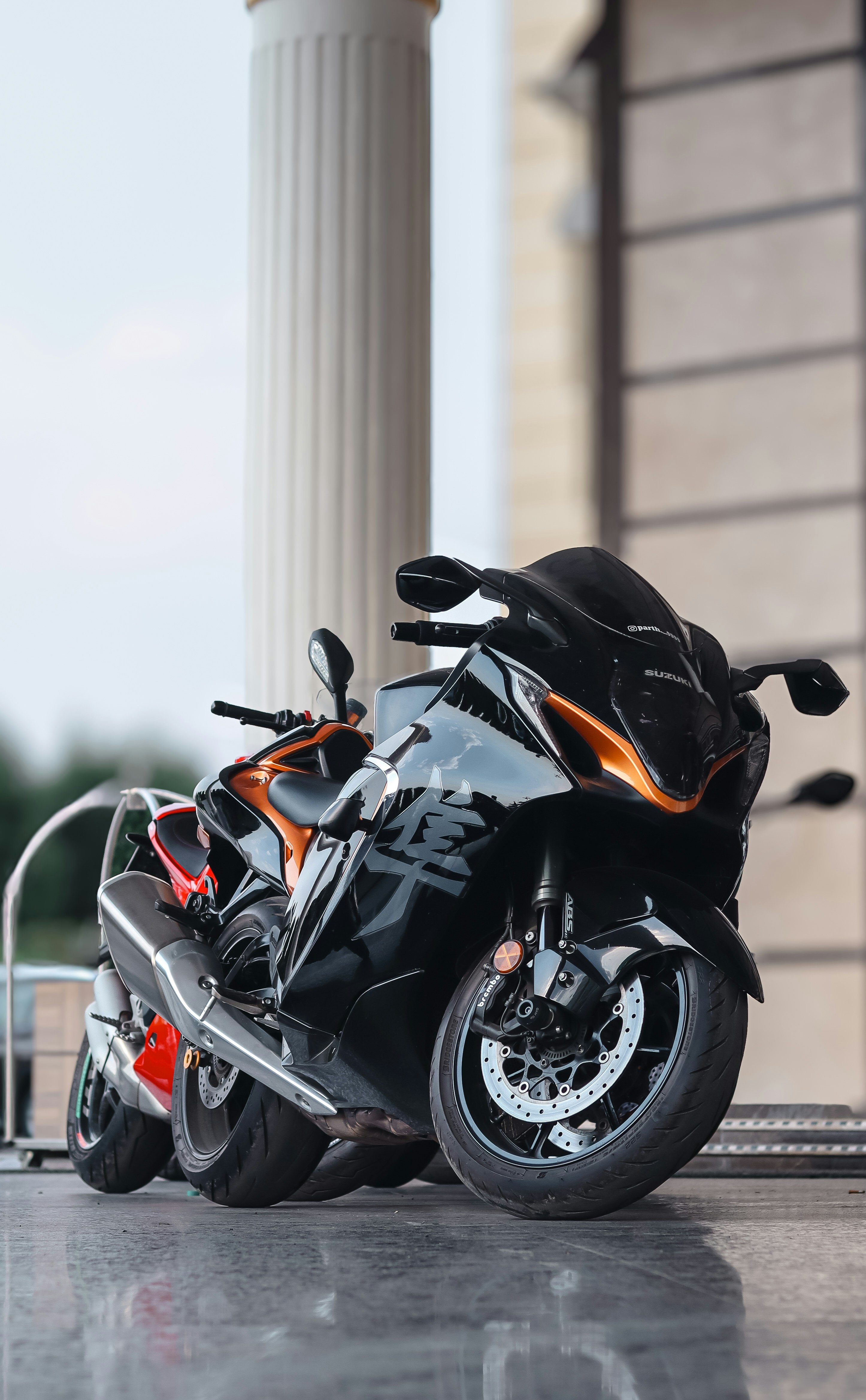 Portico Lean: A Black-Orange Sportbike Framed by Columns
