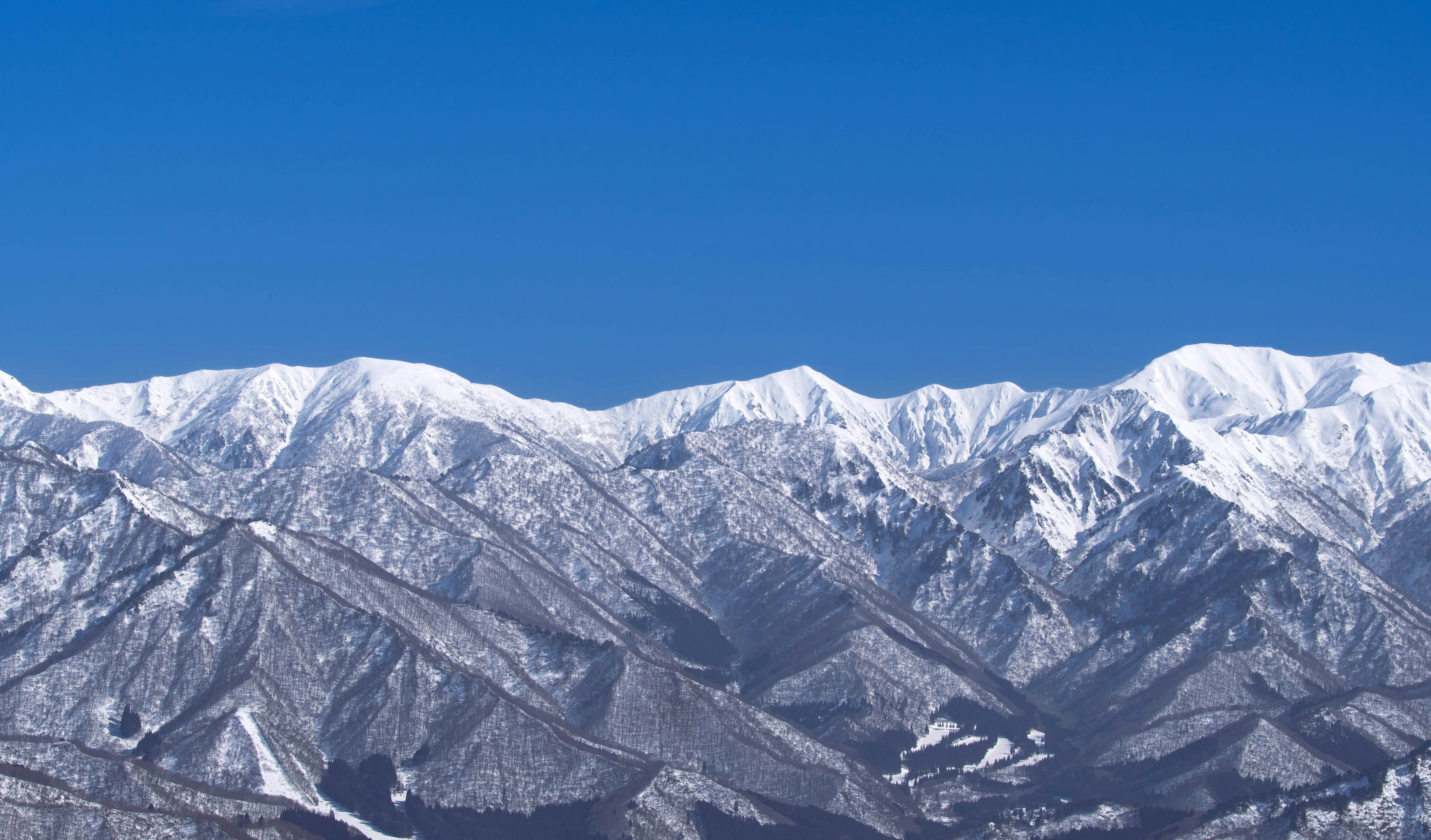 Snow-covered mountain range under a clear blue sky