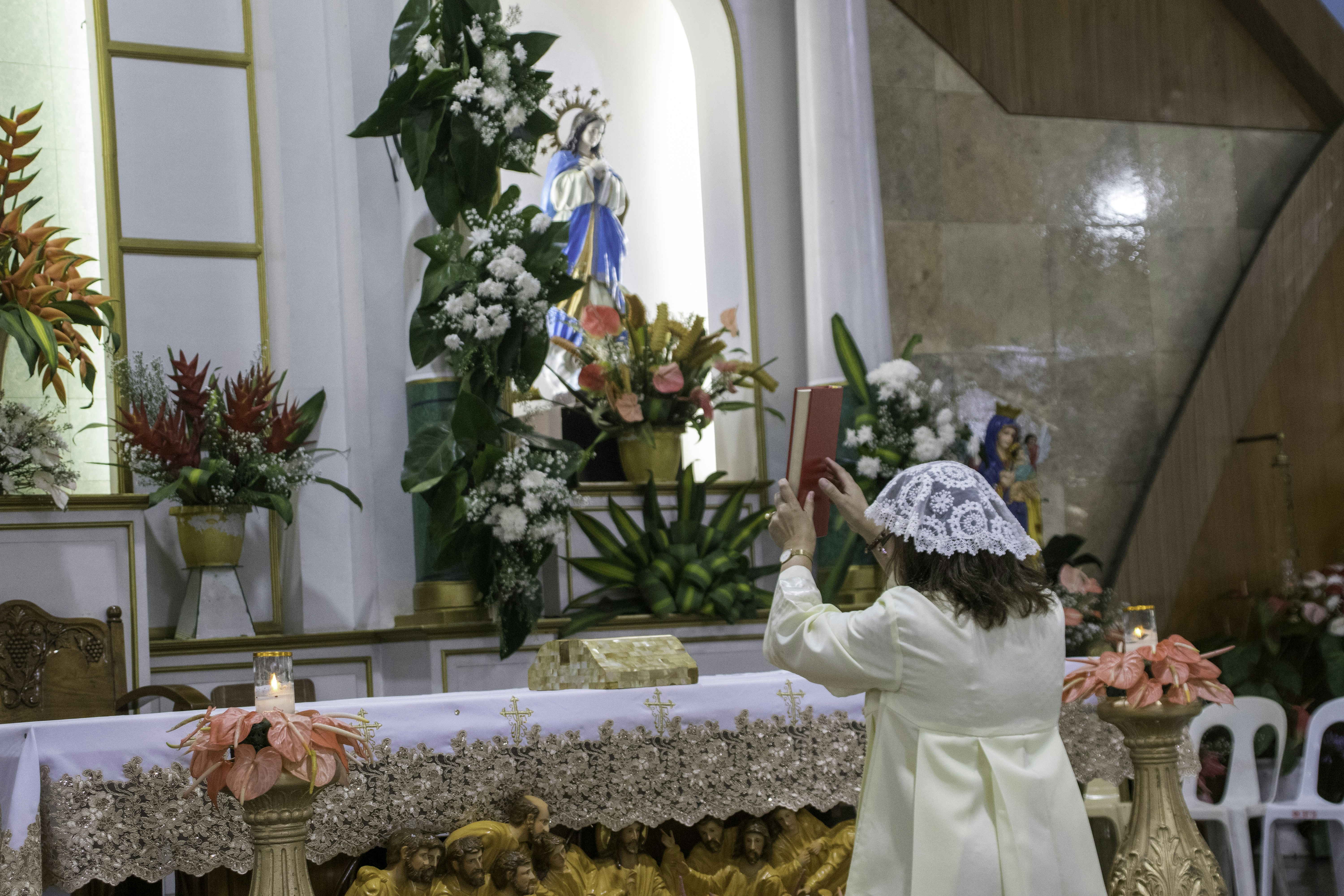 Woman holding a book at a religious altar