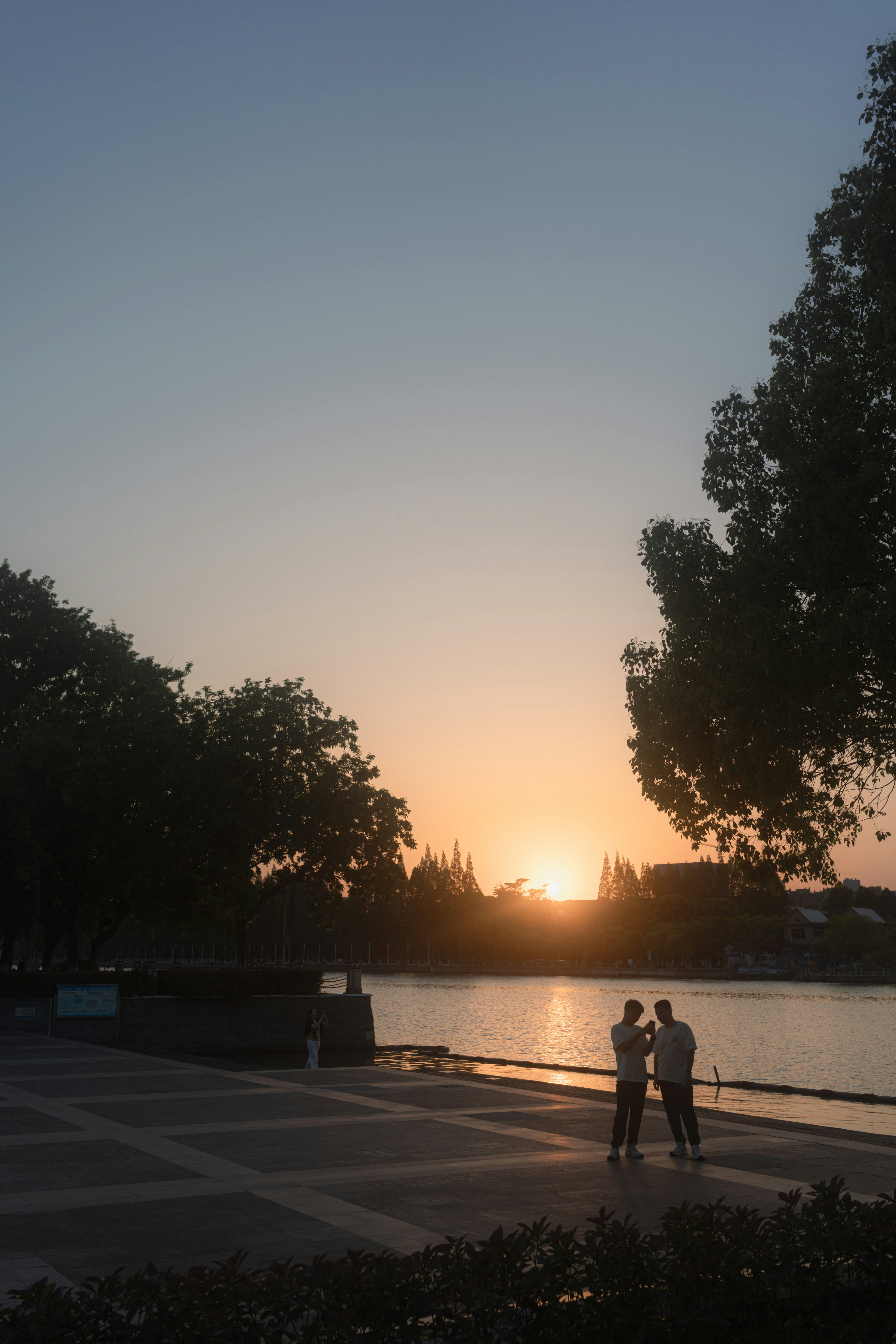Sunset Silhouettes by the Lake: Quiet Conversation at Dusk