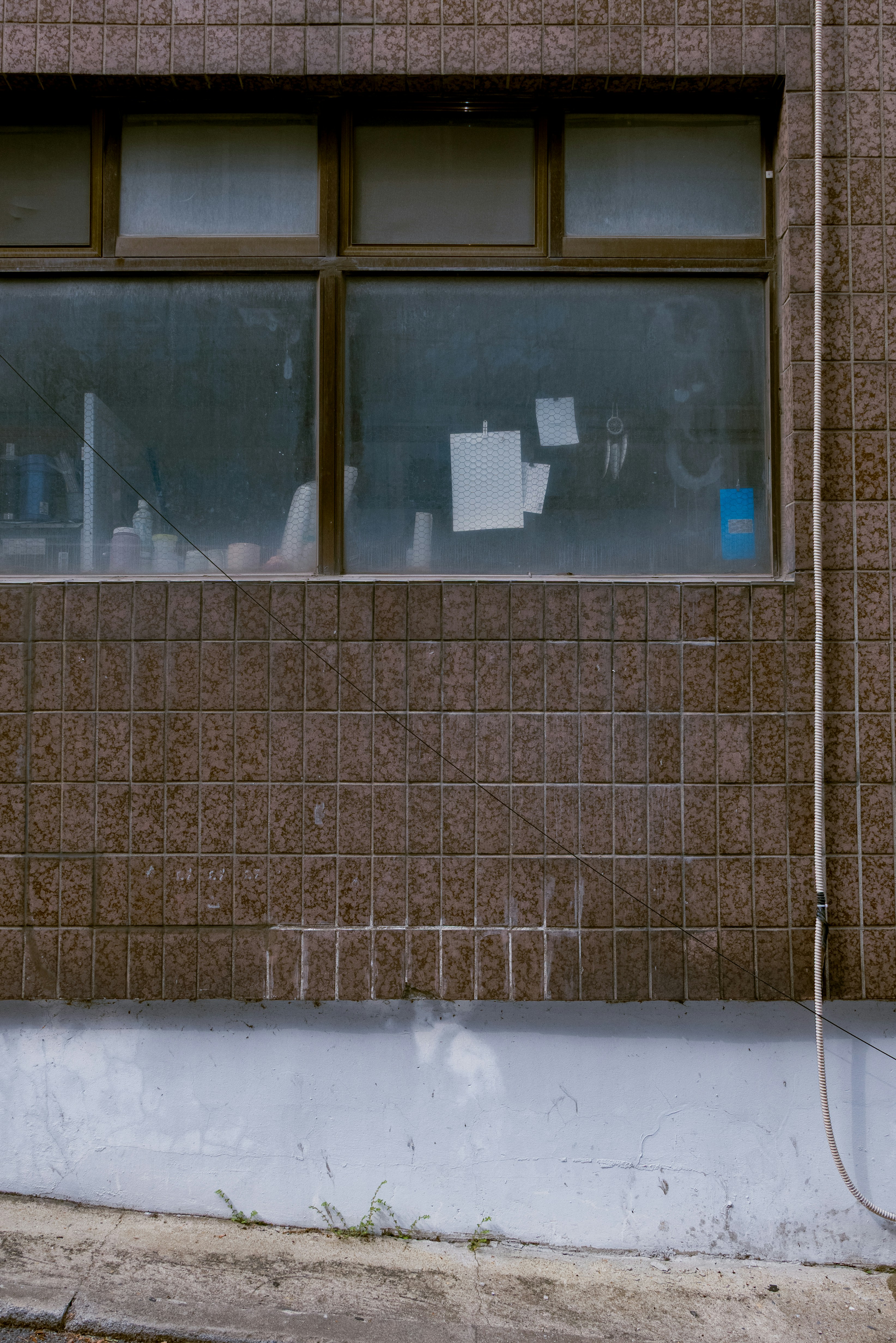 Frosted window revealing a glimpse of an indoor workspace, adorned with scattered papers and subtle reflections. 