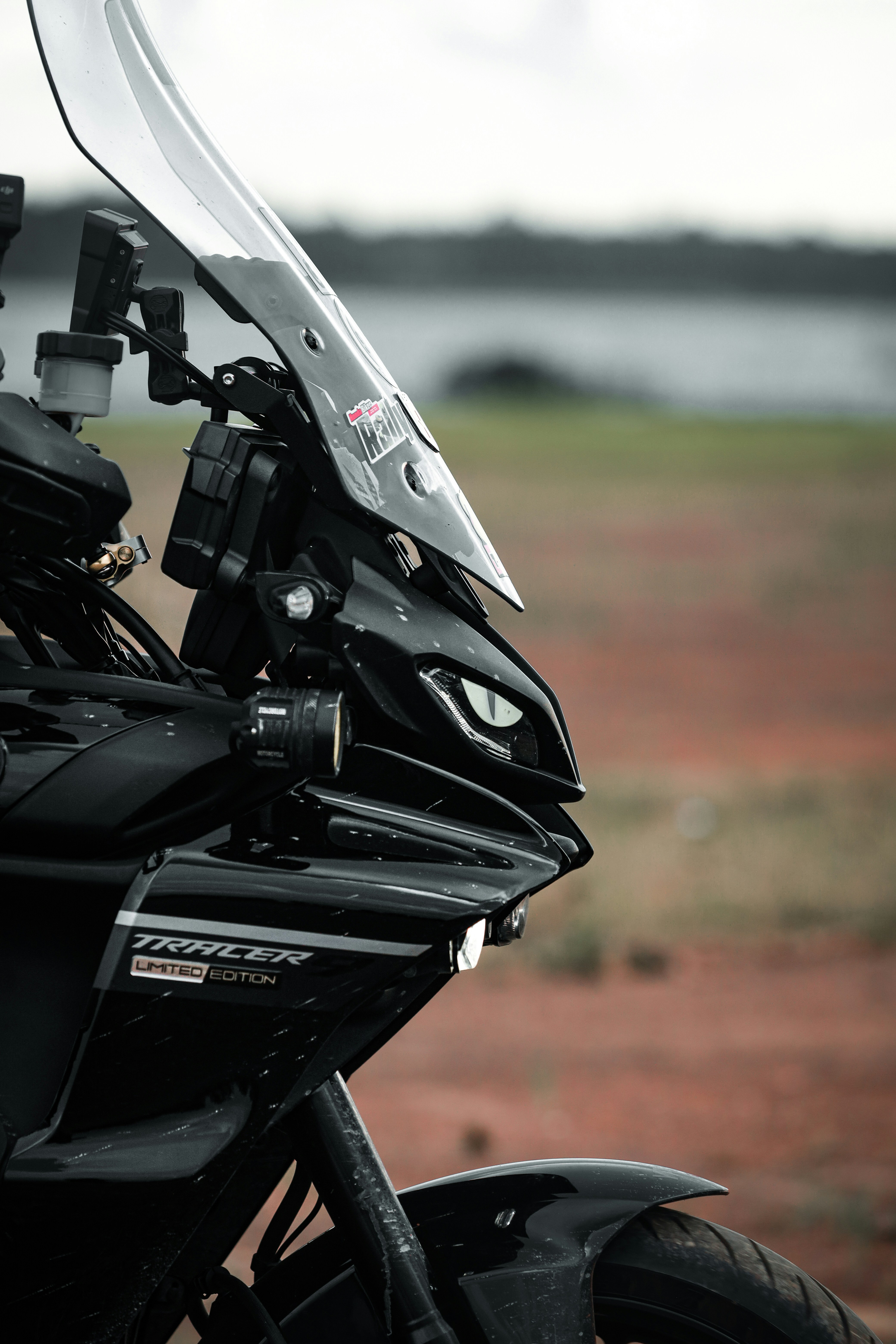 Close-up of a black motorcycle's front with a sleek windshield, showcasing its modern design and features.