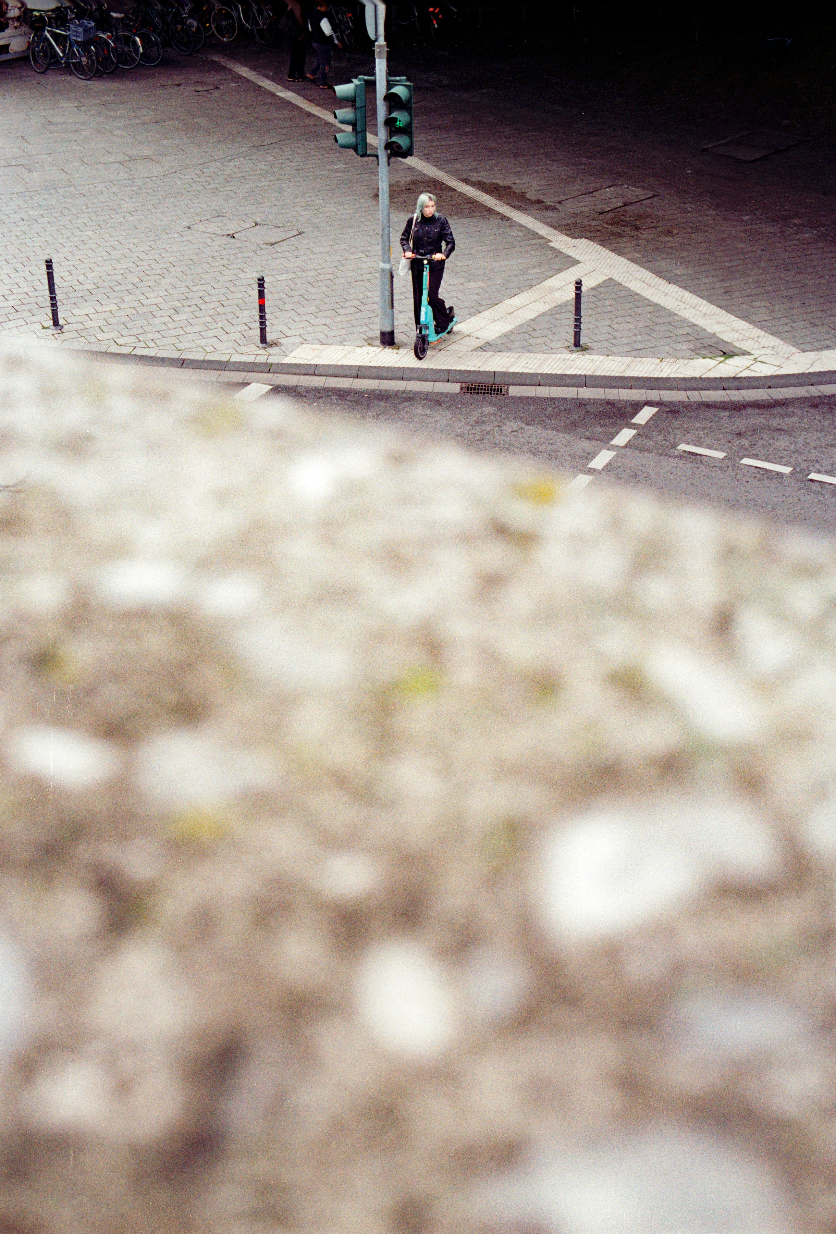 Person riding an electric scooter at intersection.