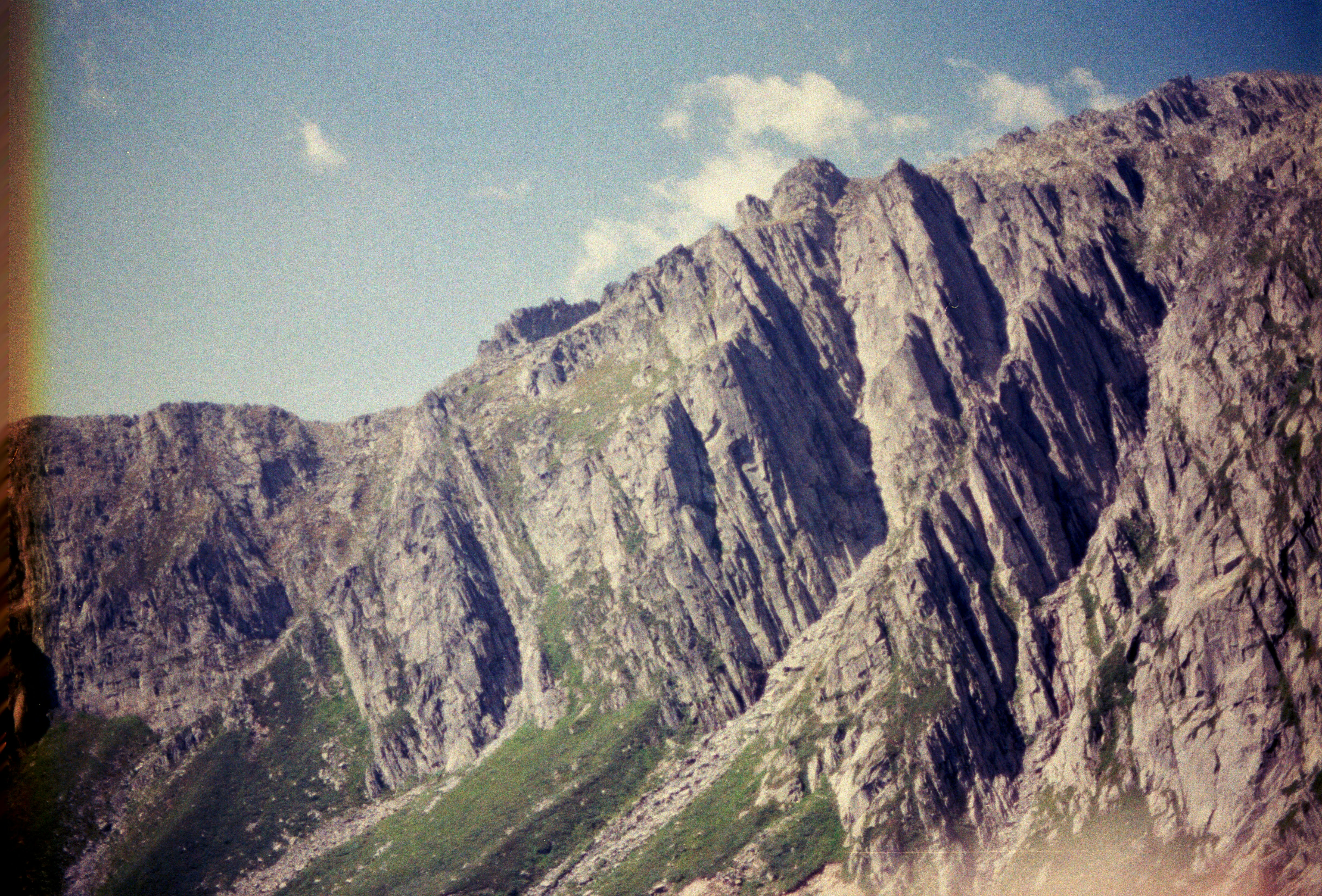 Jagged mountain range under a cloudy blue sky