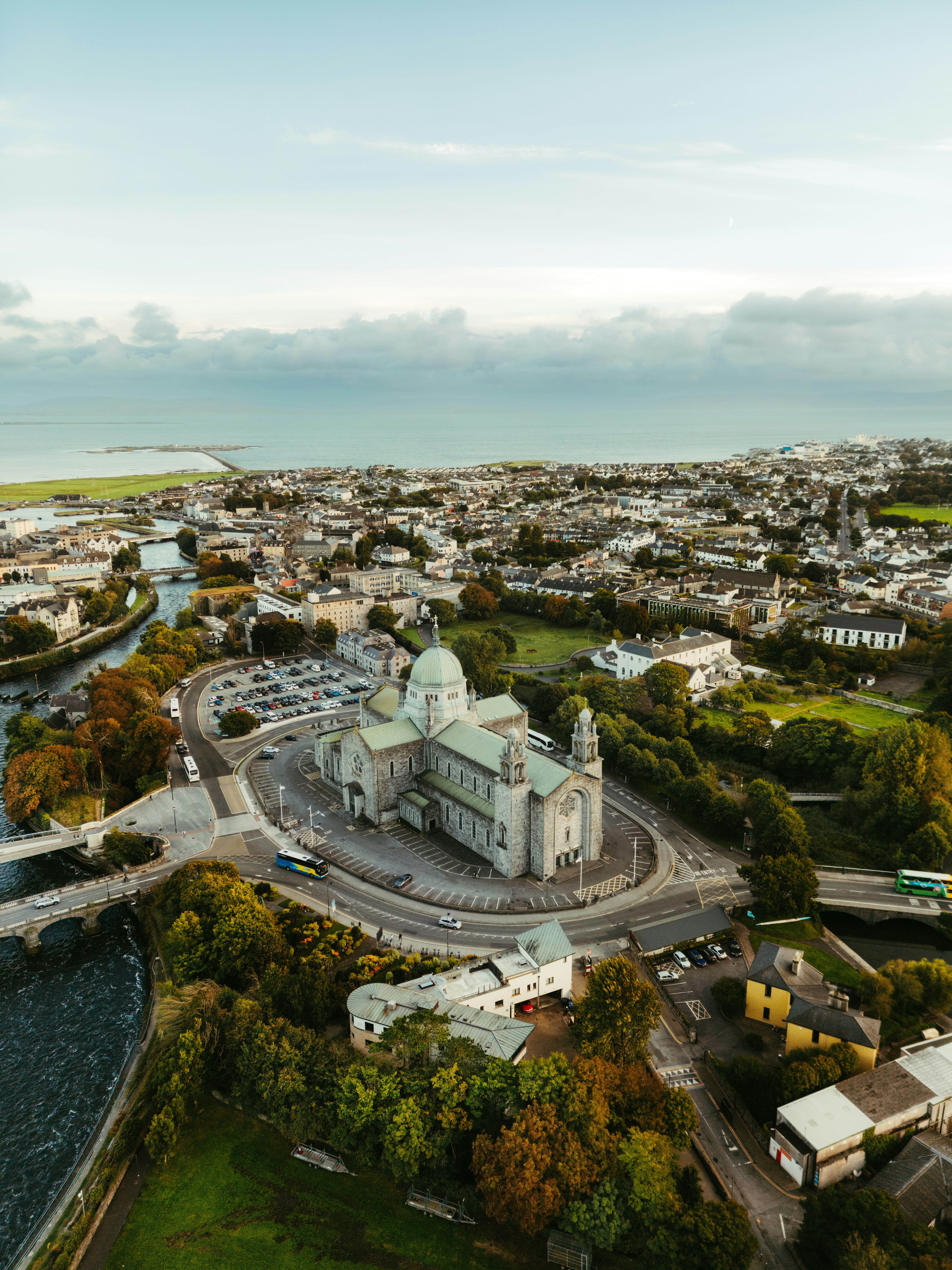 Aerial view of a large cathedral overlooking a coastal city.