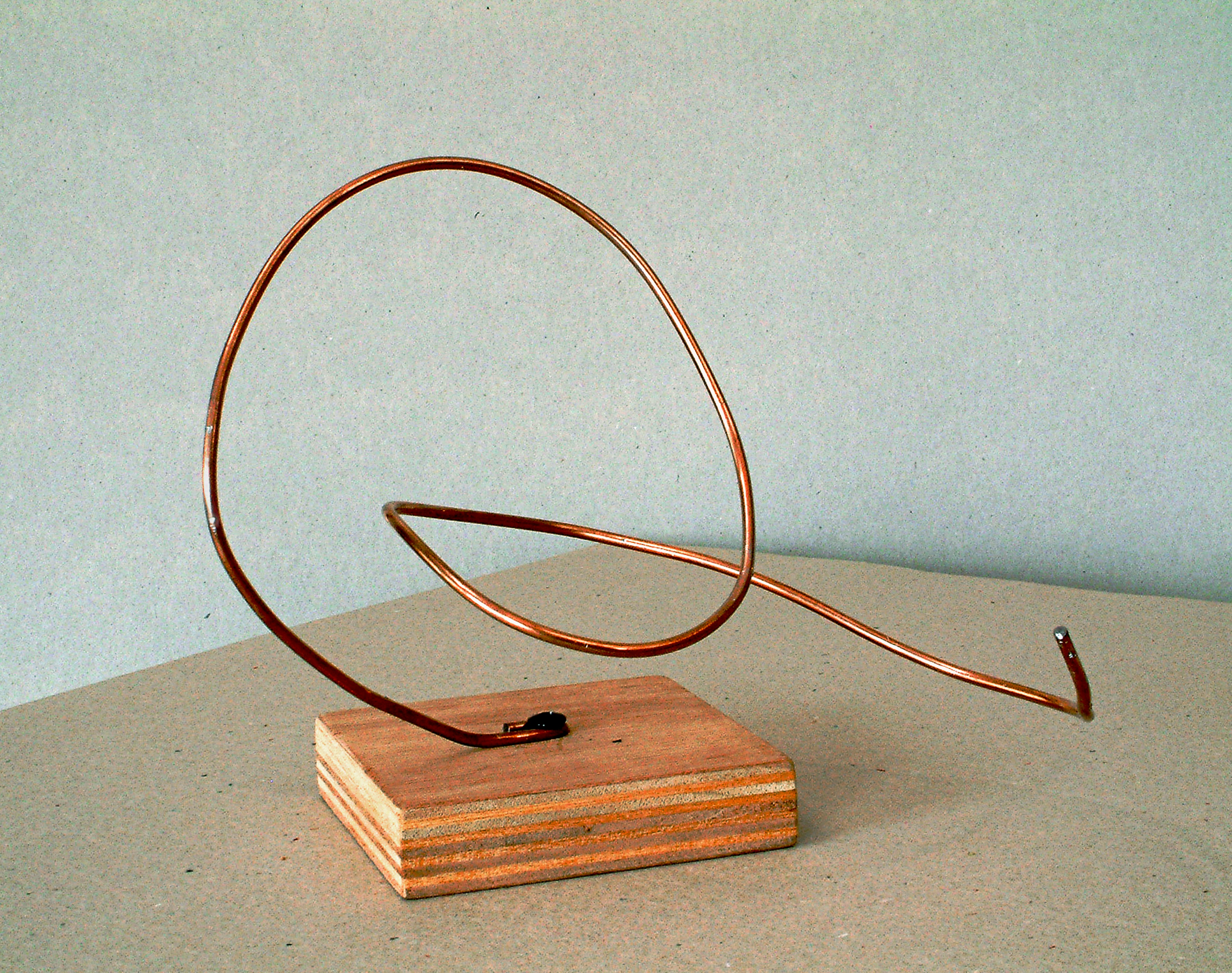 'Wire sculpture 2.' curving copper wire sculpture on a wooden foot - abstract art image, made by Dutch artist Fons Heijnsbroek in 2005 - free download image. | Copper wire sculpture on wooden base