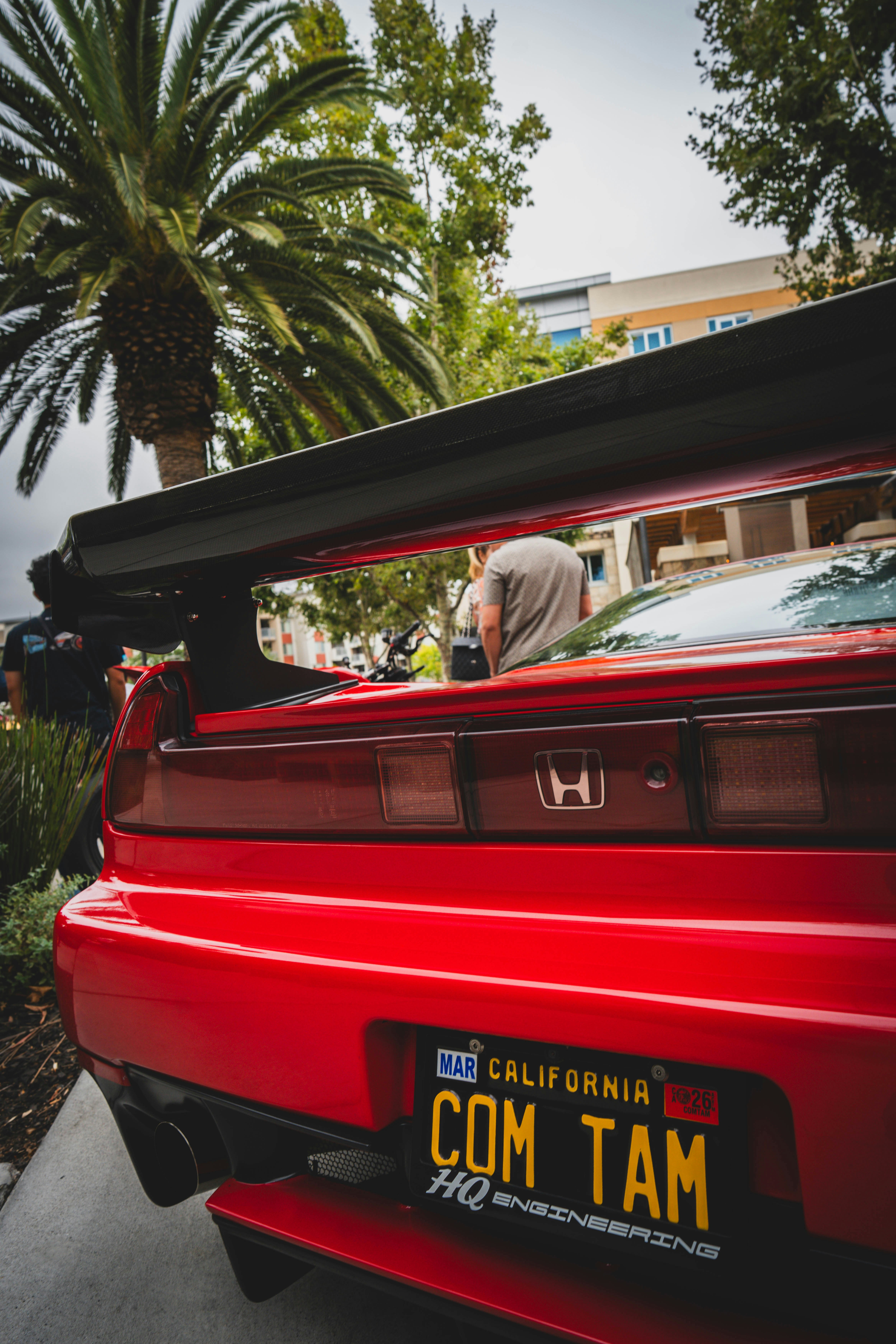Red sports car with spoiler and california license plate.