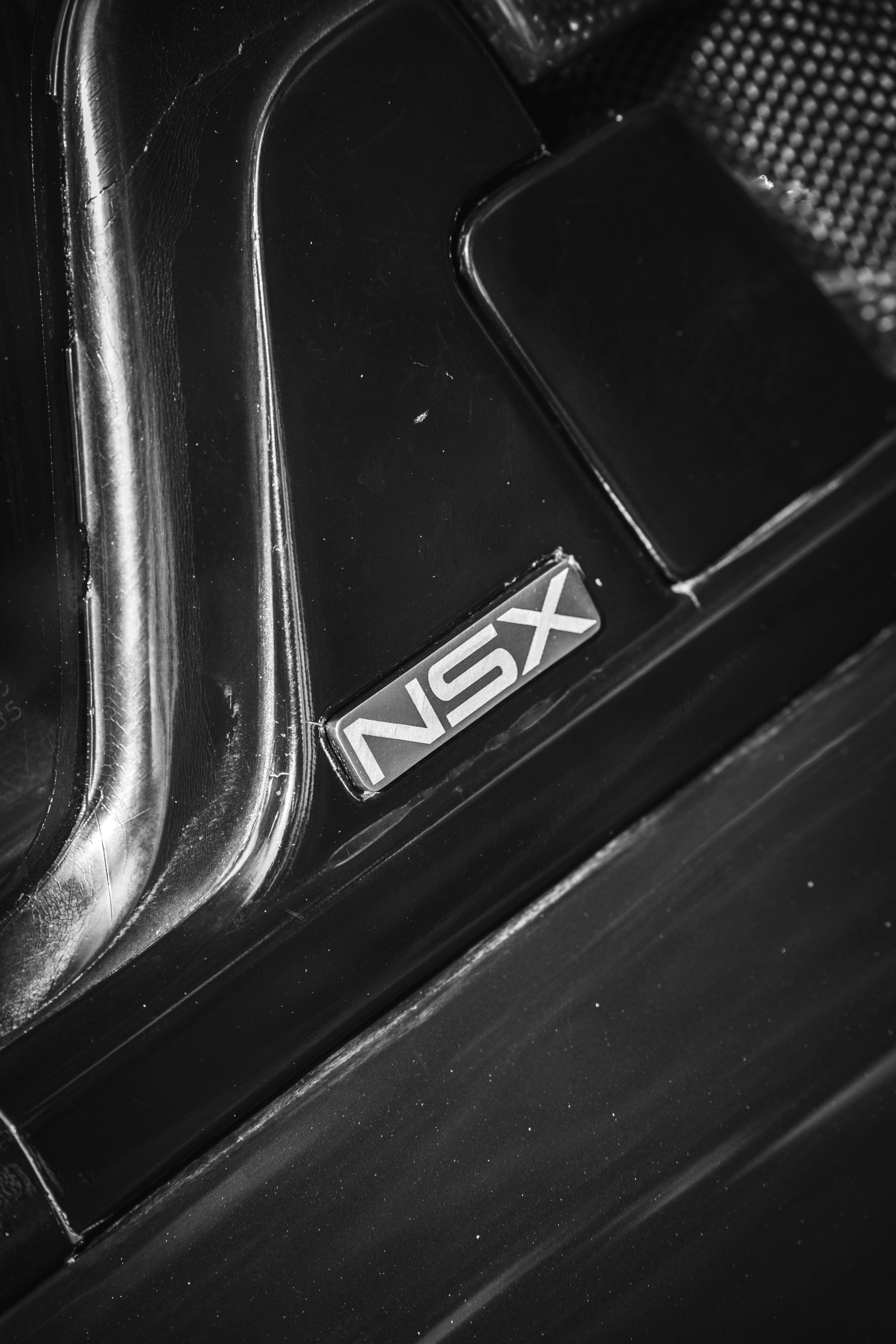 Close-up of a black nsx car emblem